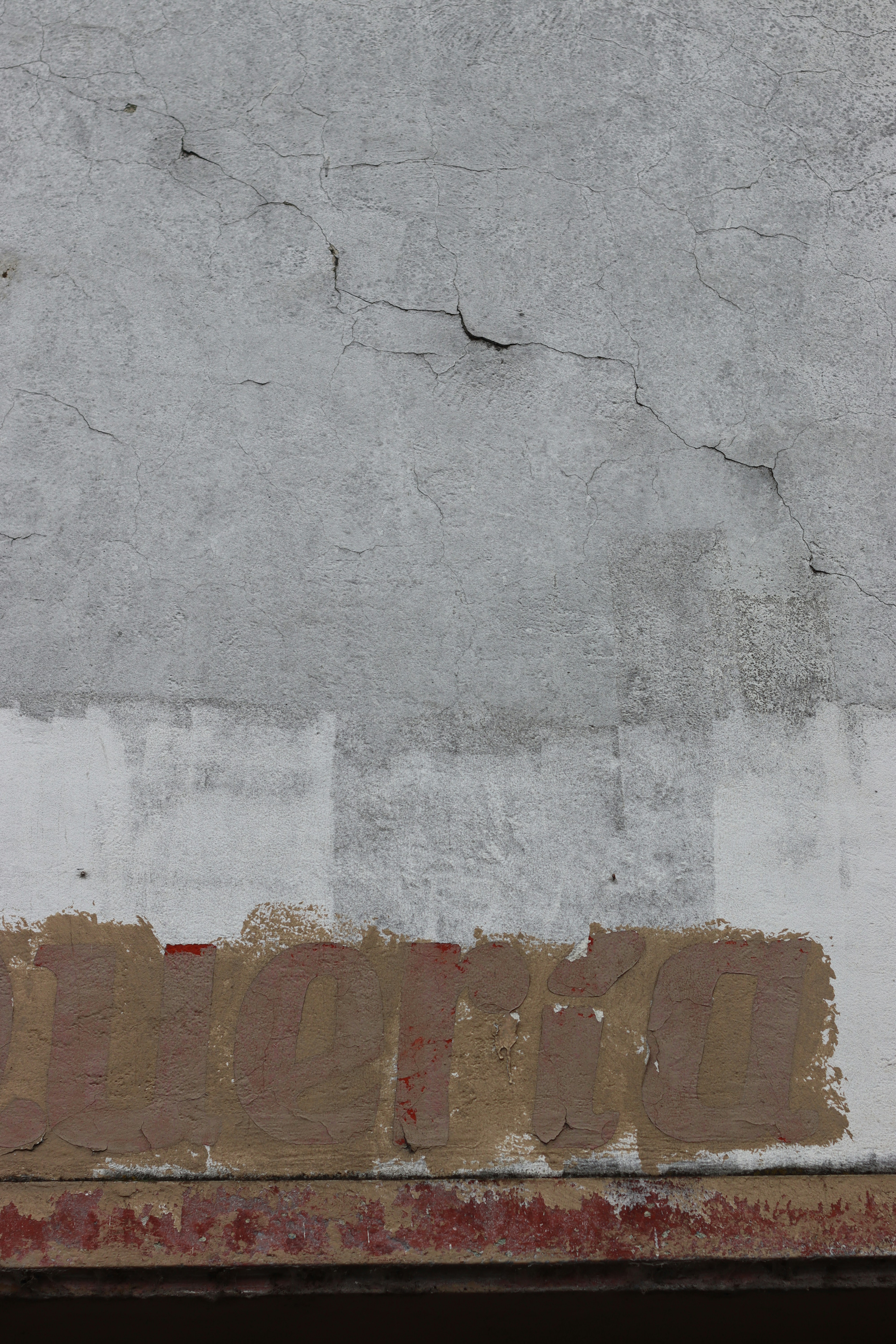 Weathered wall shows peeling paint and cracks.