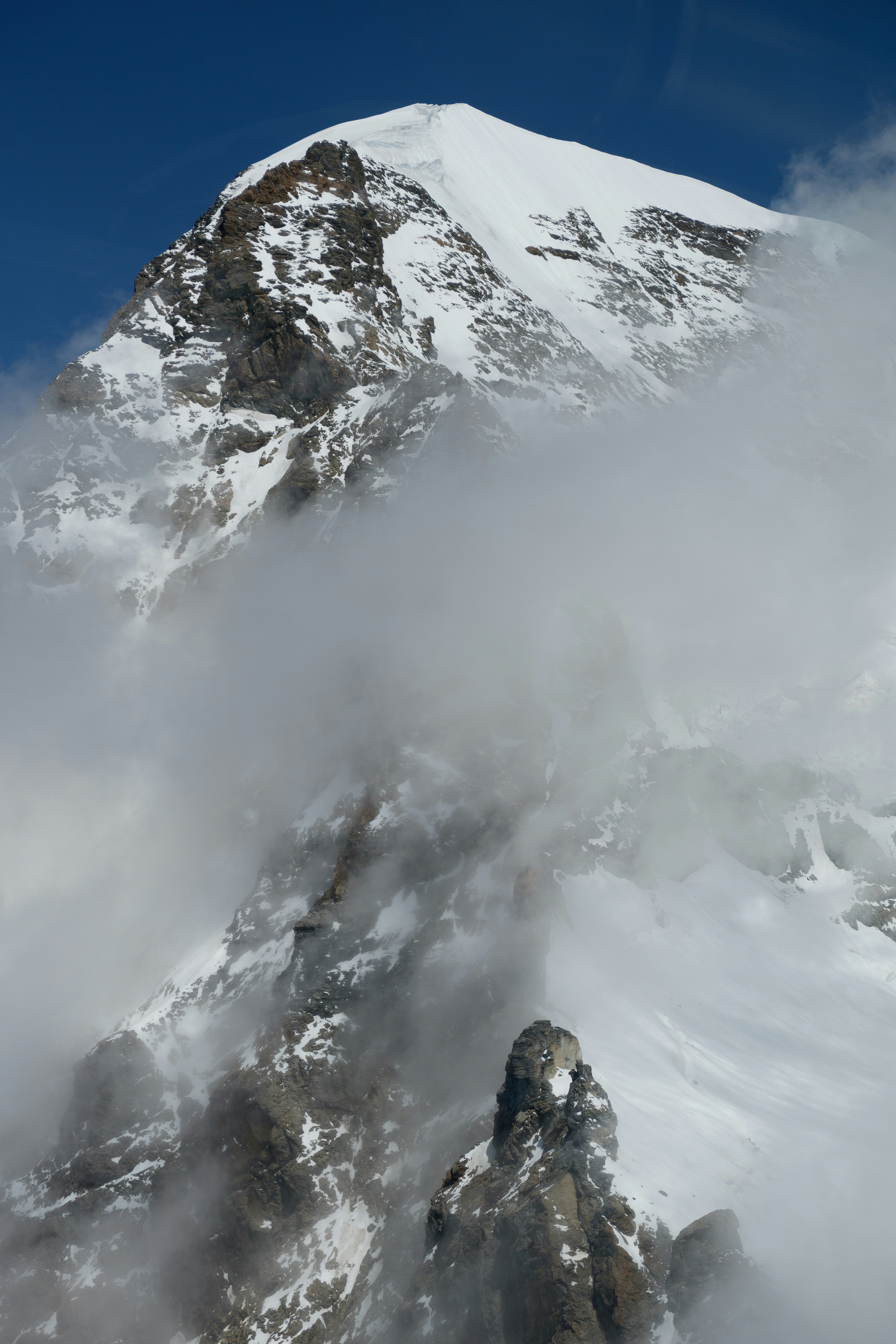 Veil of Clouds Over Majestic Peaks