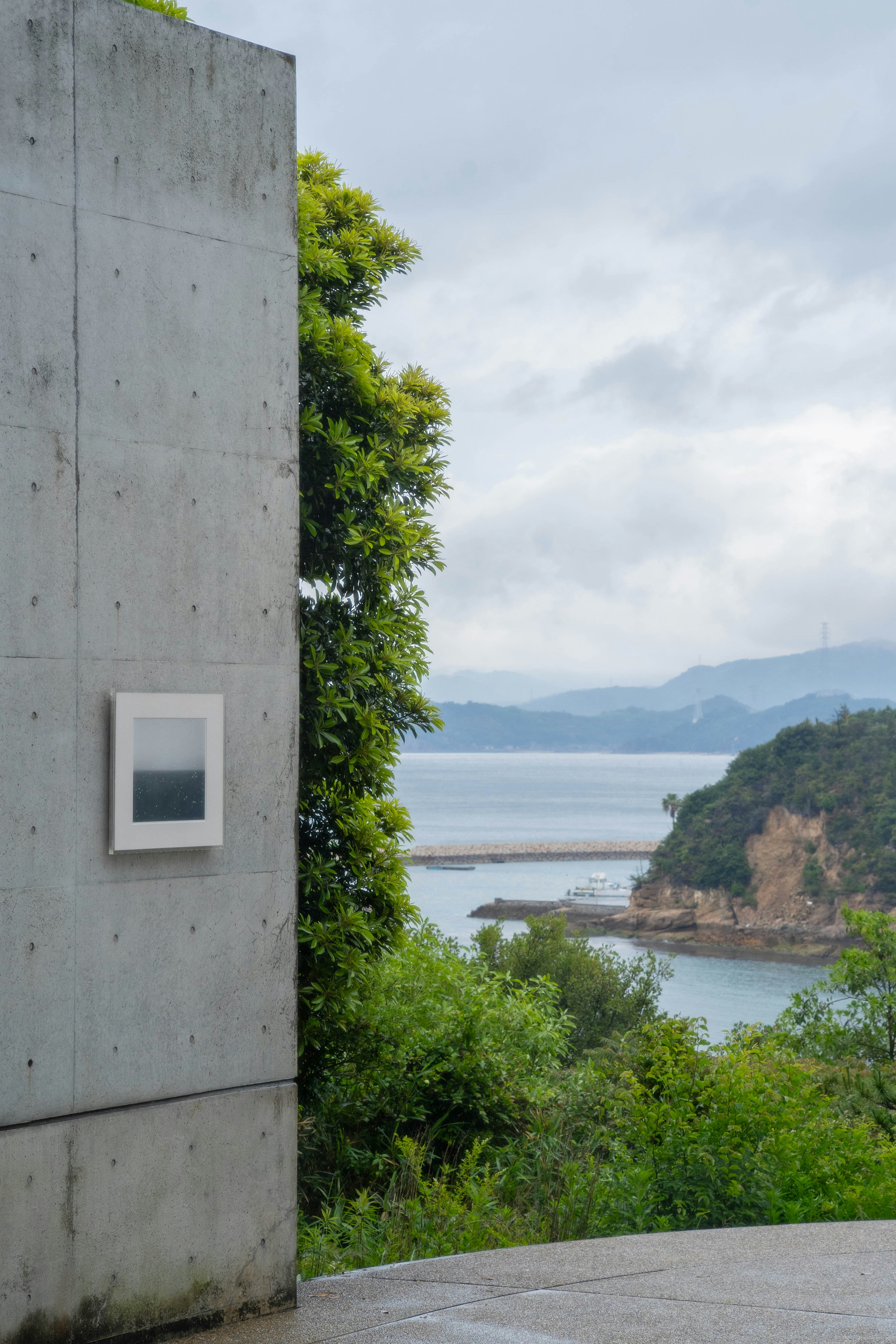 A concrete wall frames a calming coastal view.