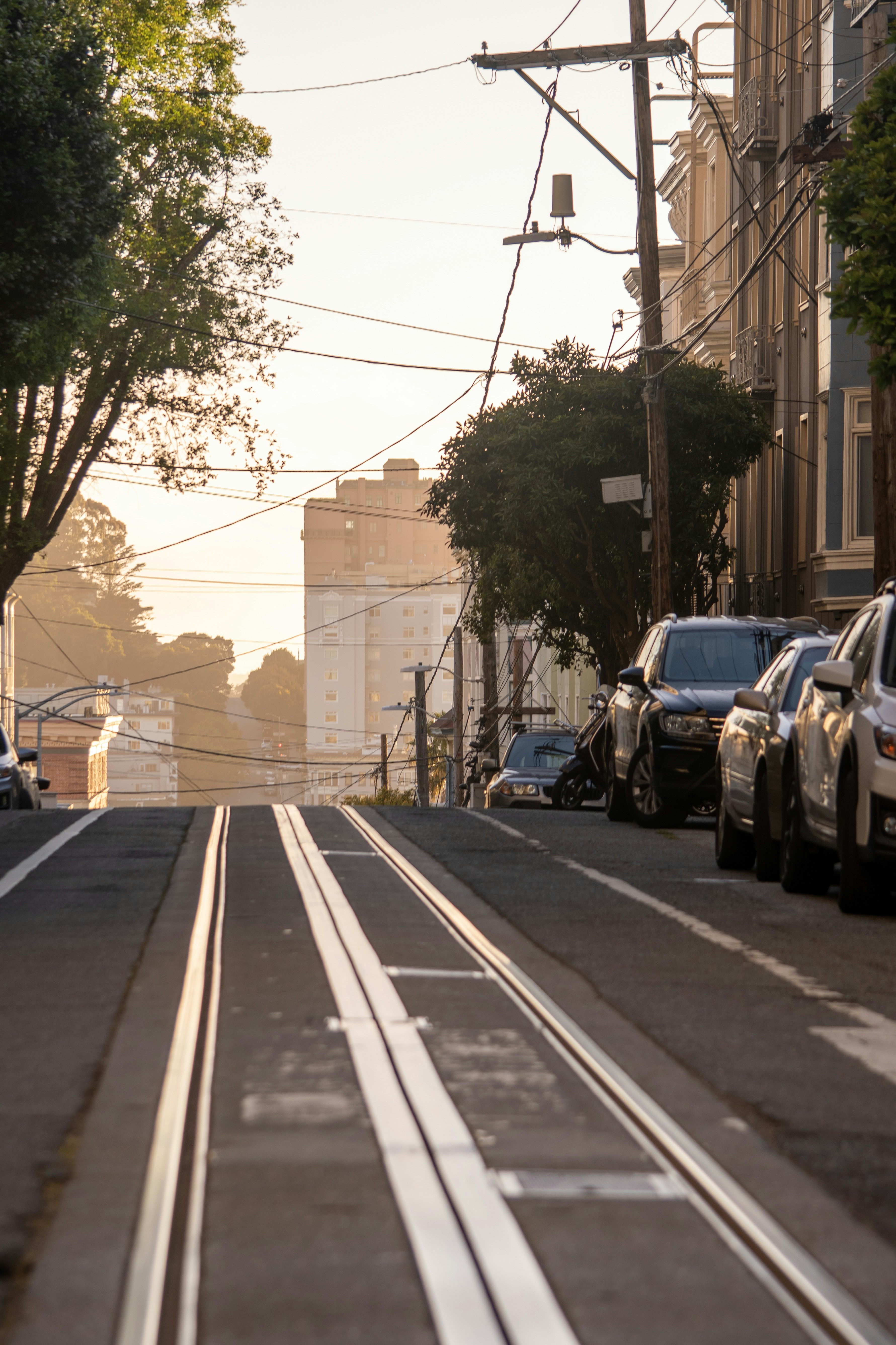 Sunset in San Francisco | Street view with tram tracks and parked cars.