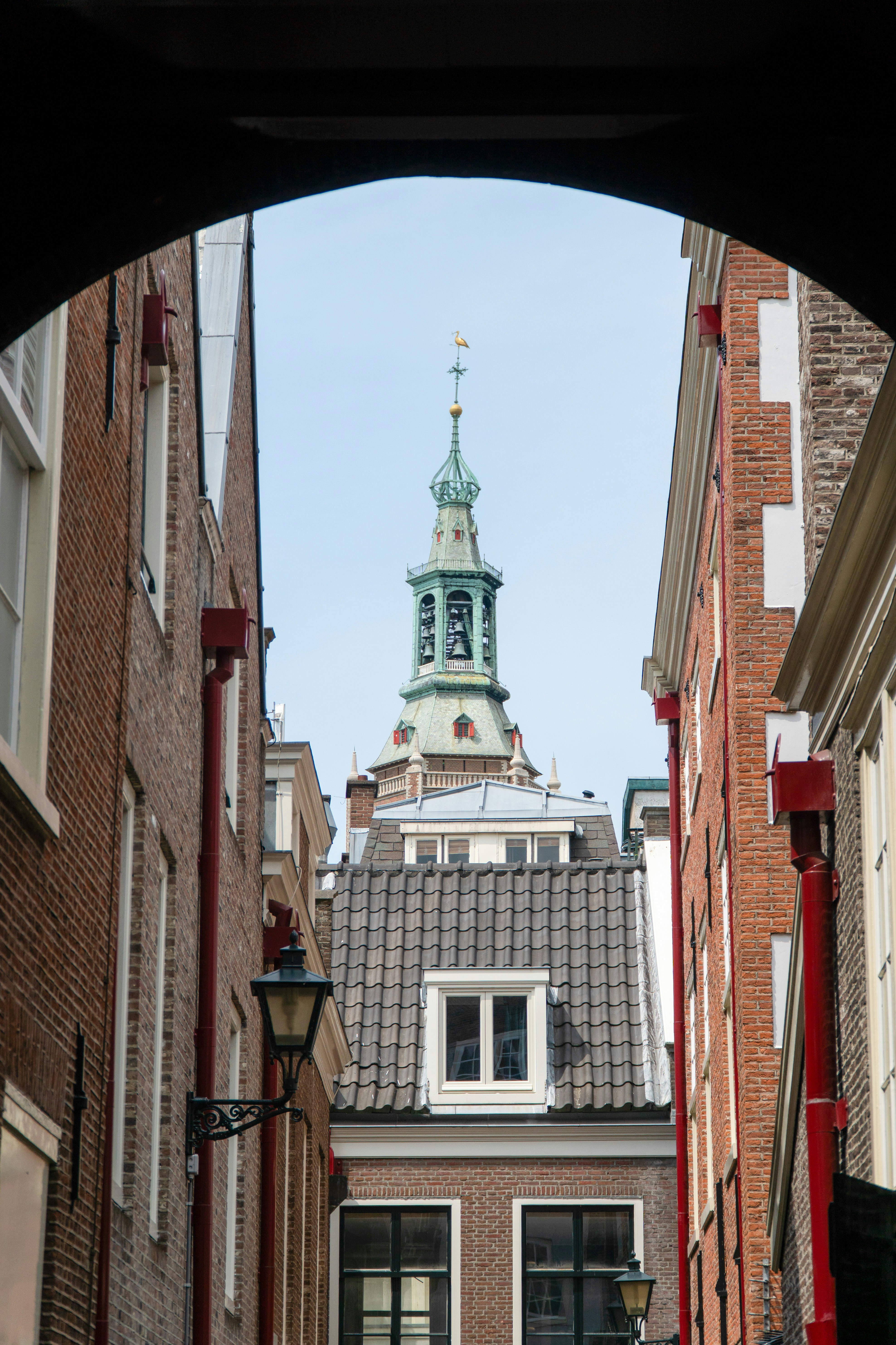 A small alley in The Hague, Netherlands | A church tower seen through an archway.