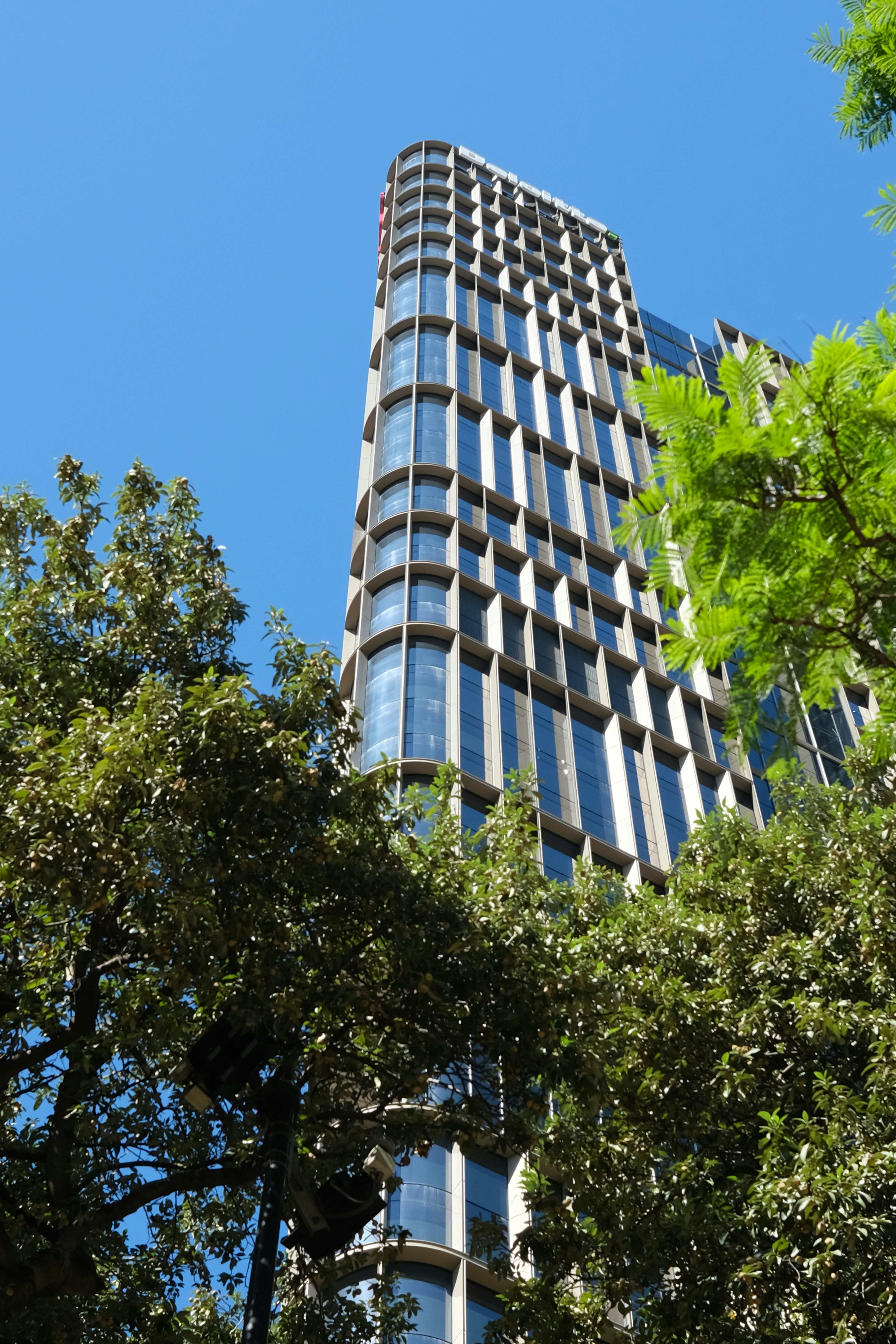 A tall building reaches for the blue sky.
