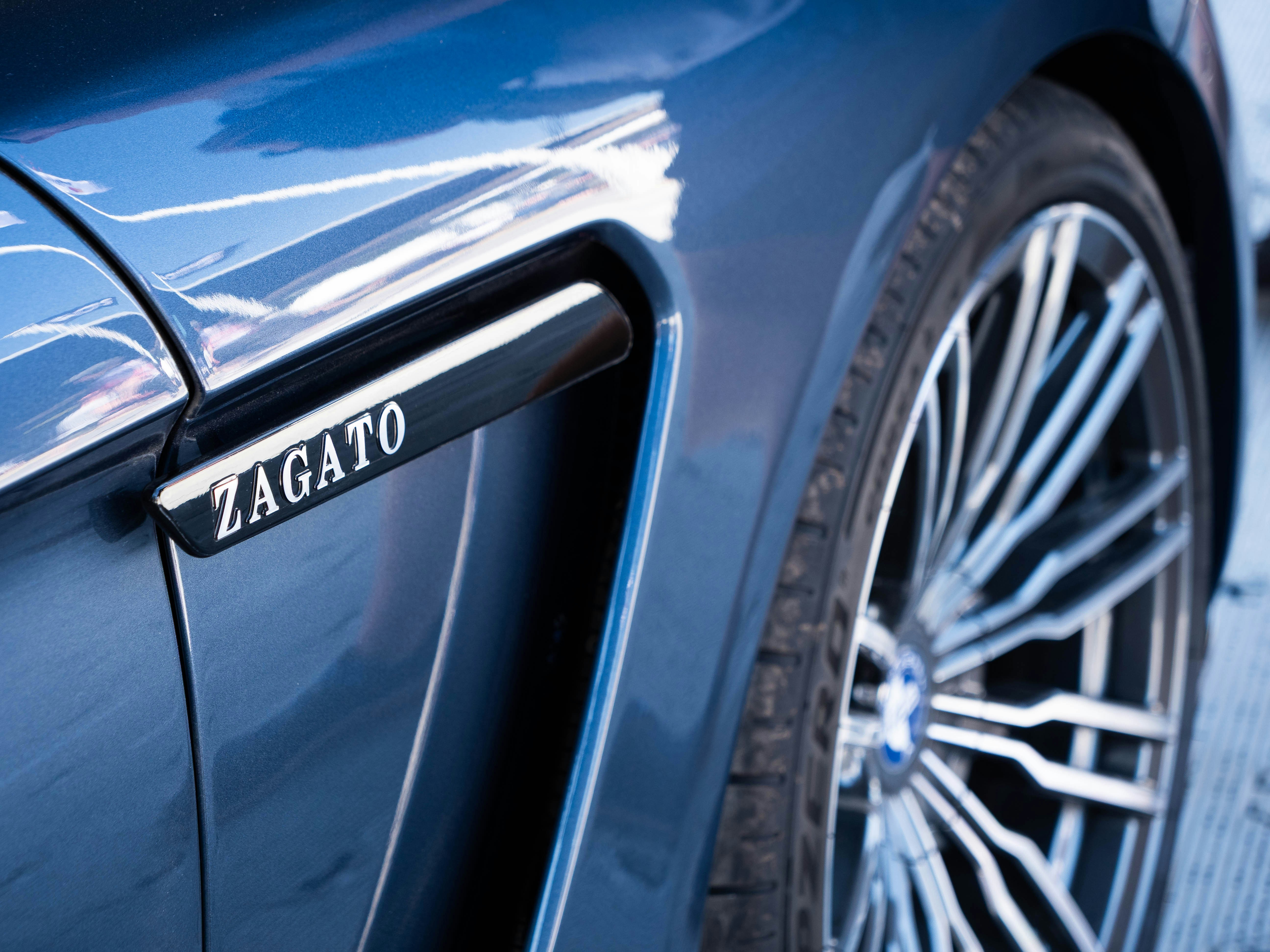 Close up of the Zagato brandng on a car. | A blue car showing the zagato emblem.