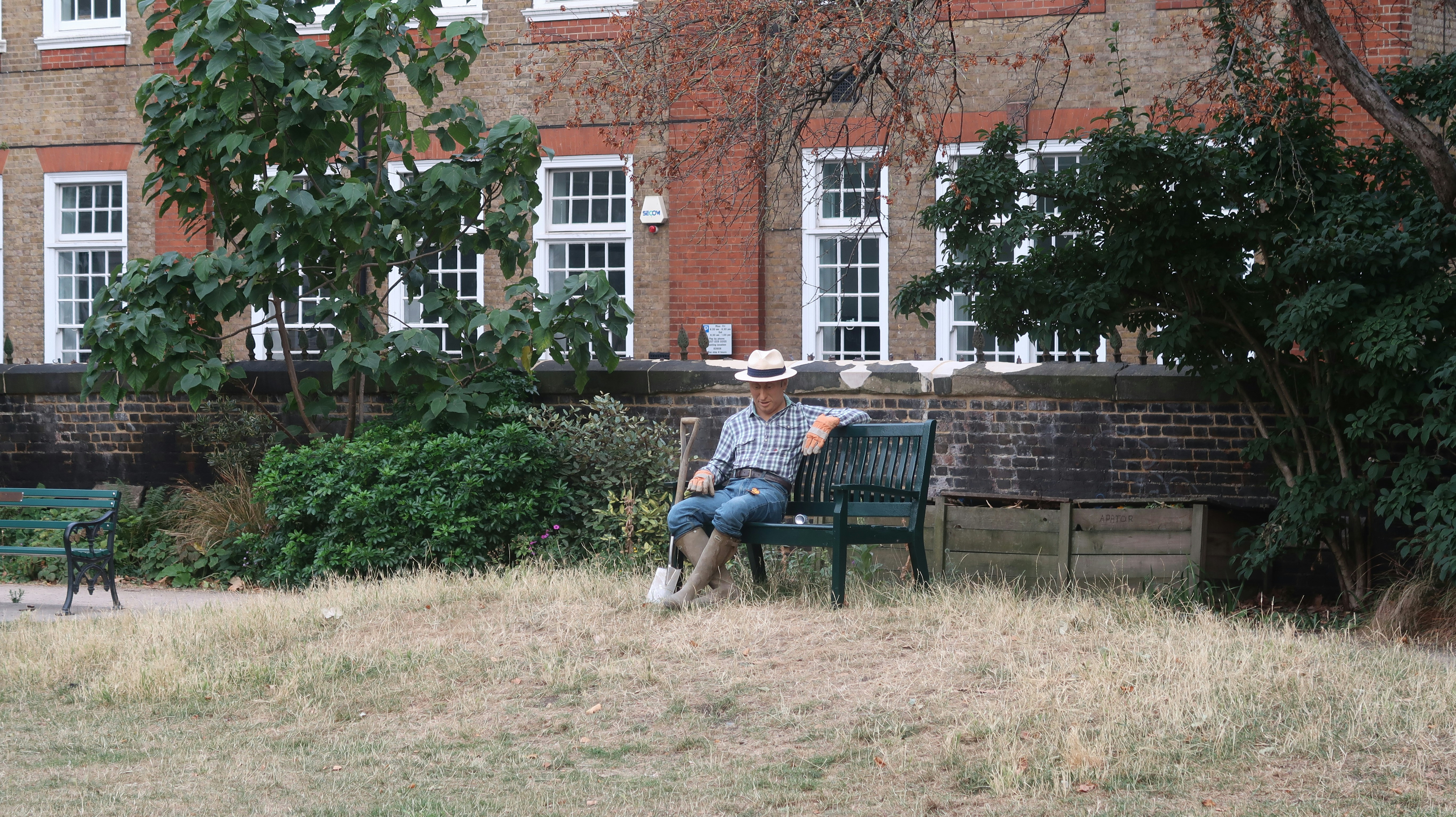 A man sits on a bench near a building.