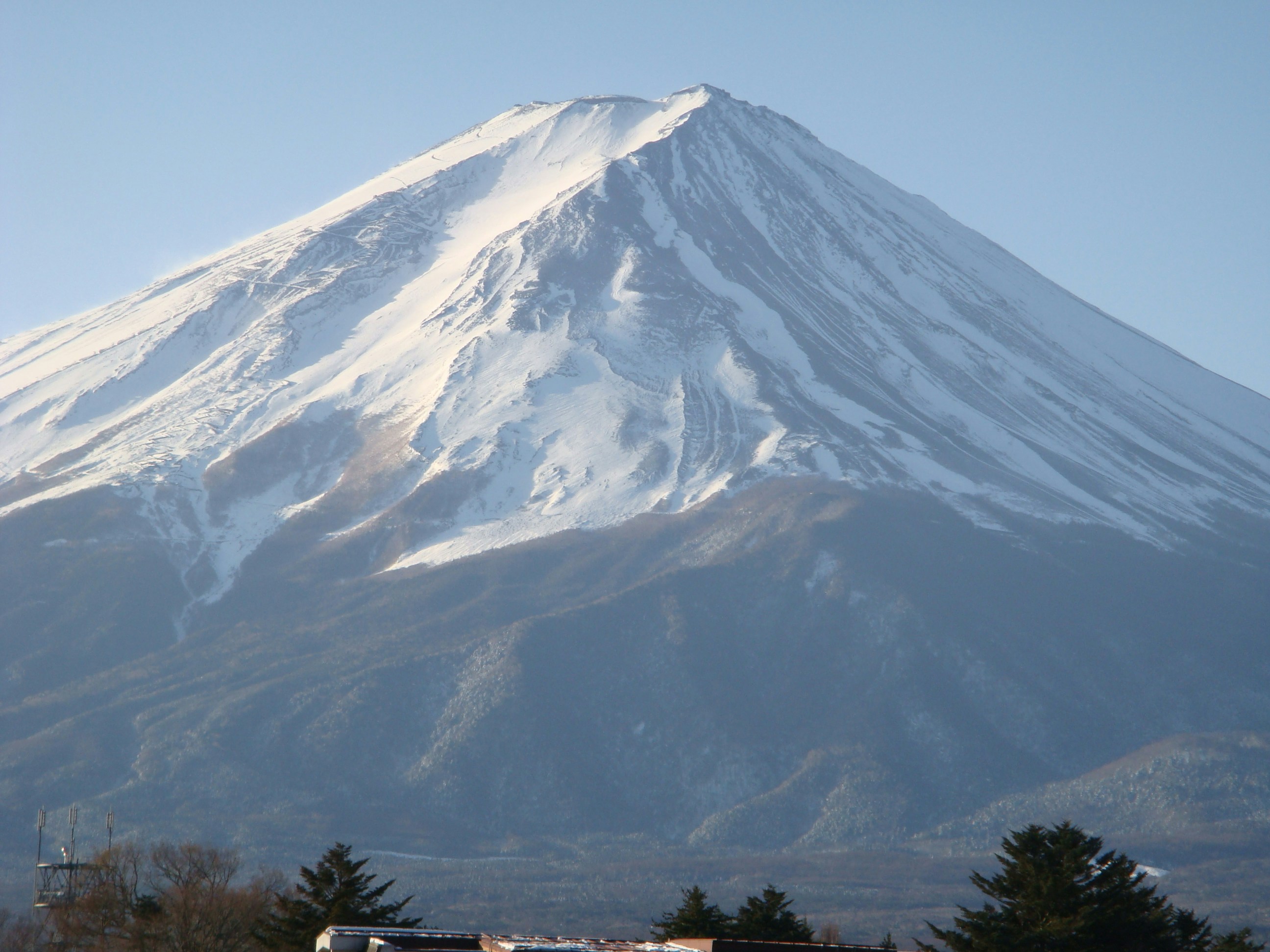 Snow-capped mount fuji stands majestically under a blue sky.