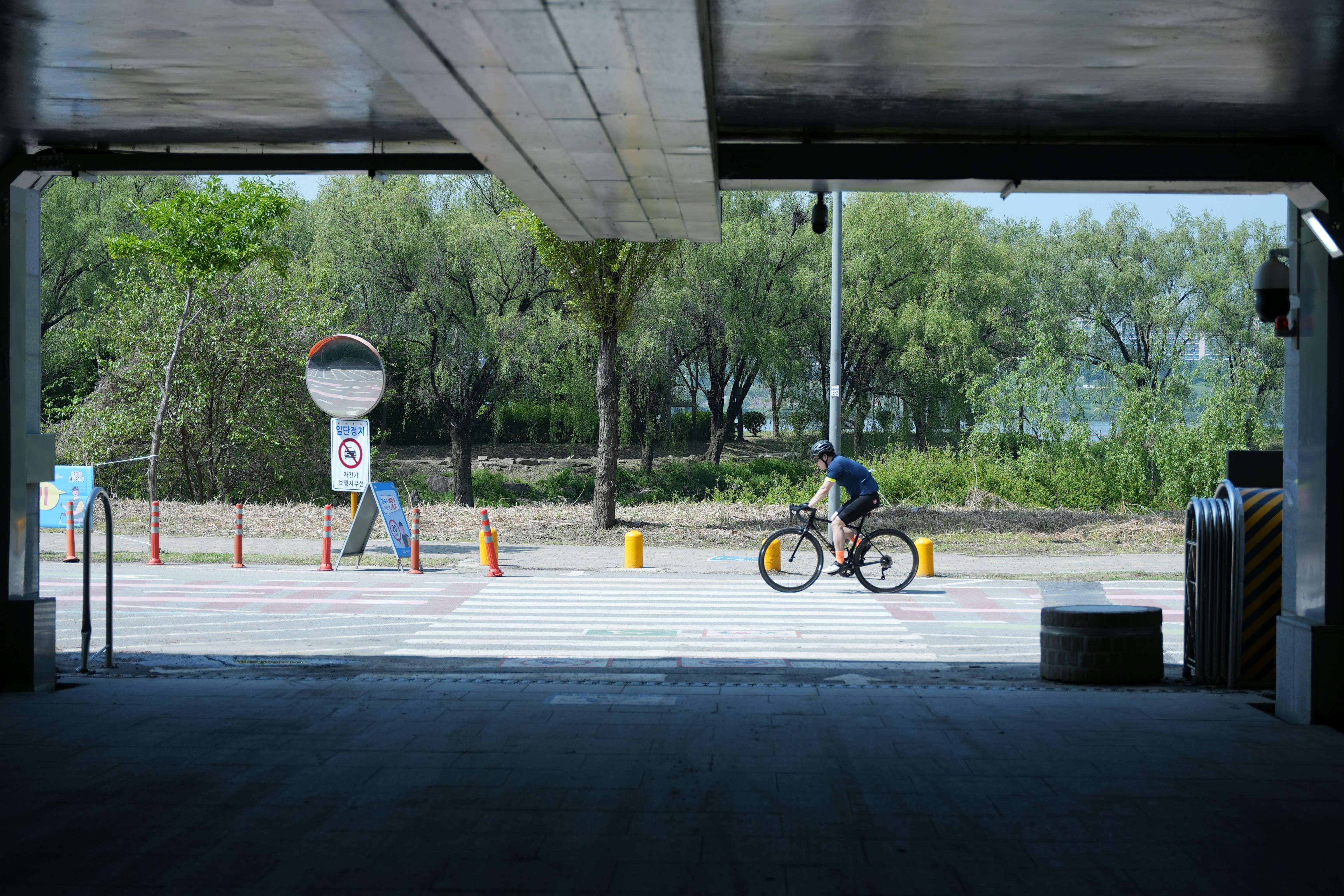A cyclist rides underneath a structure.