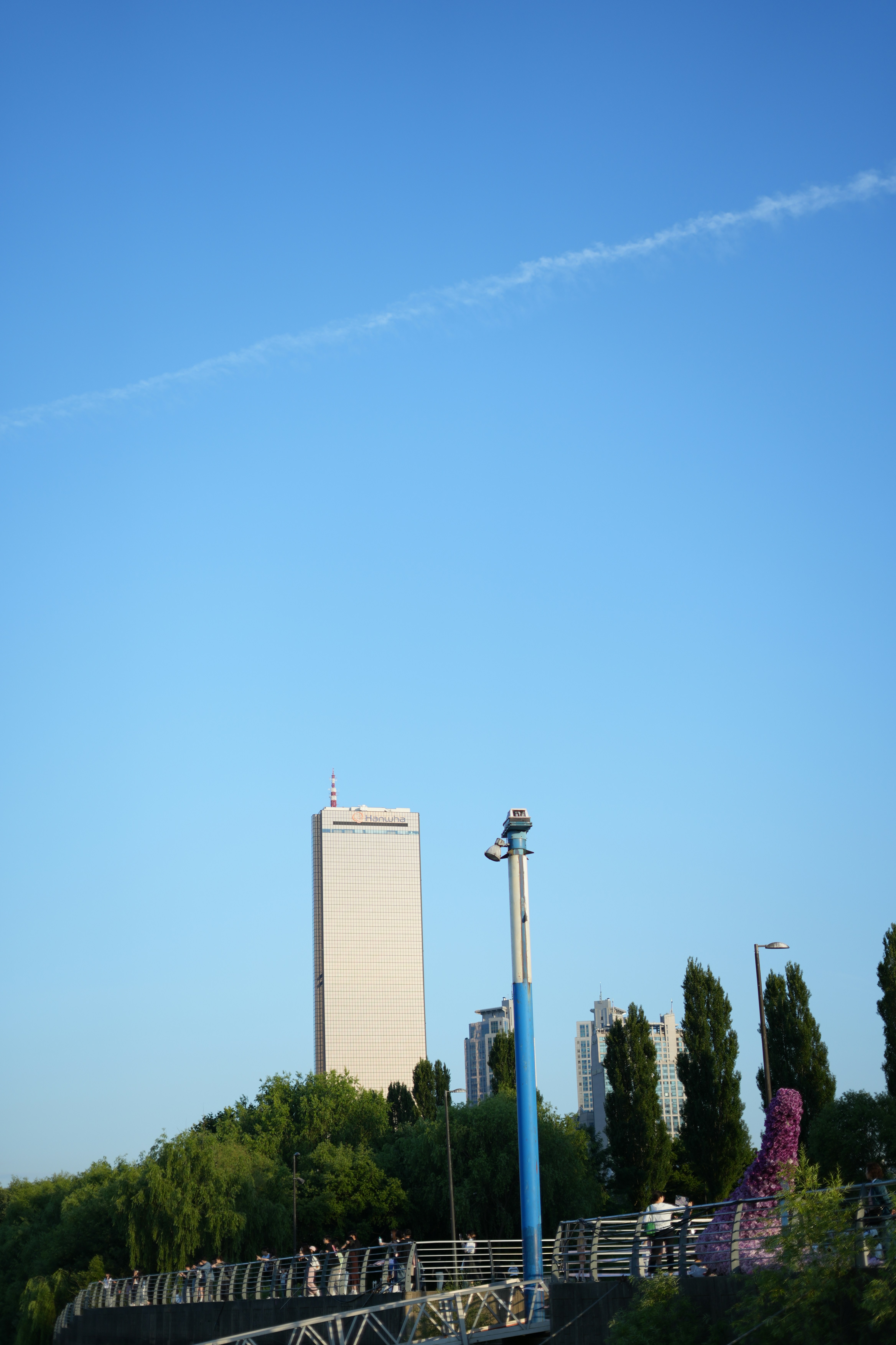 A city building stands tall against a blue sky.