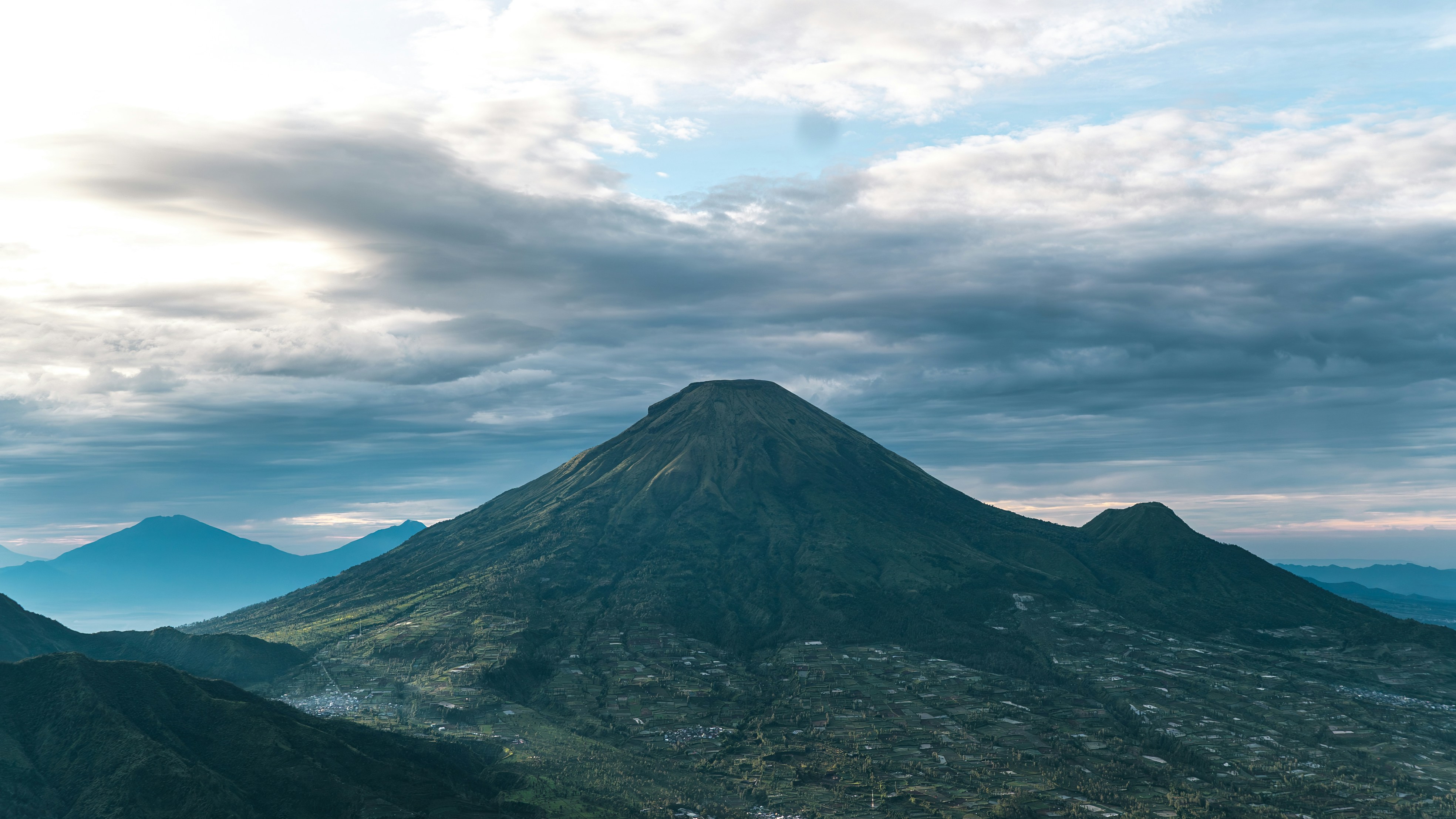 A majestic mountain peaks under cloudy skies.