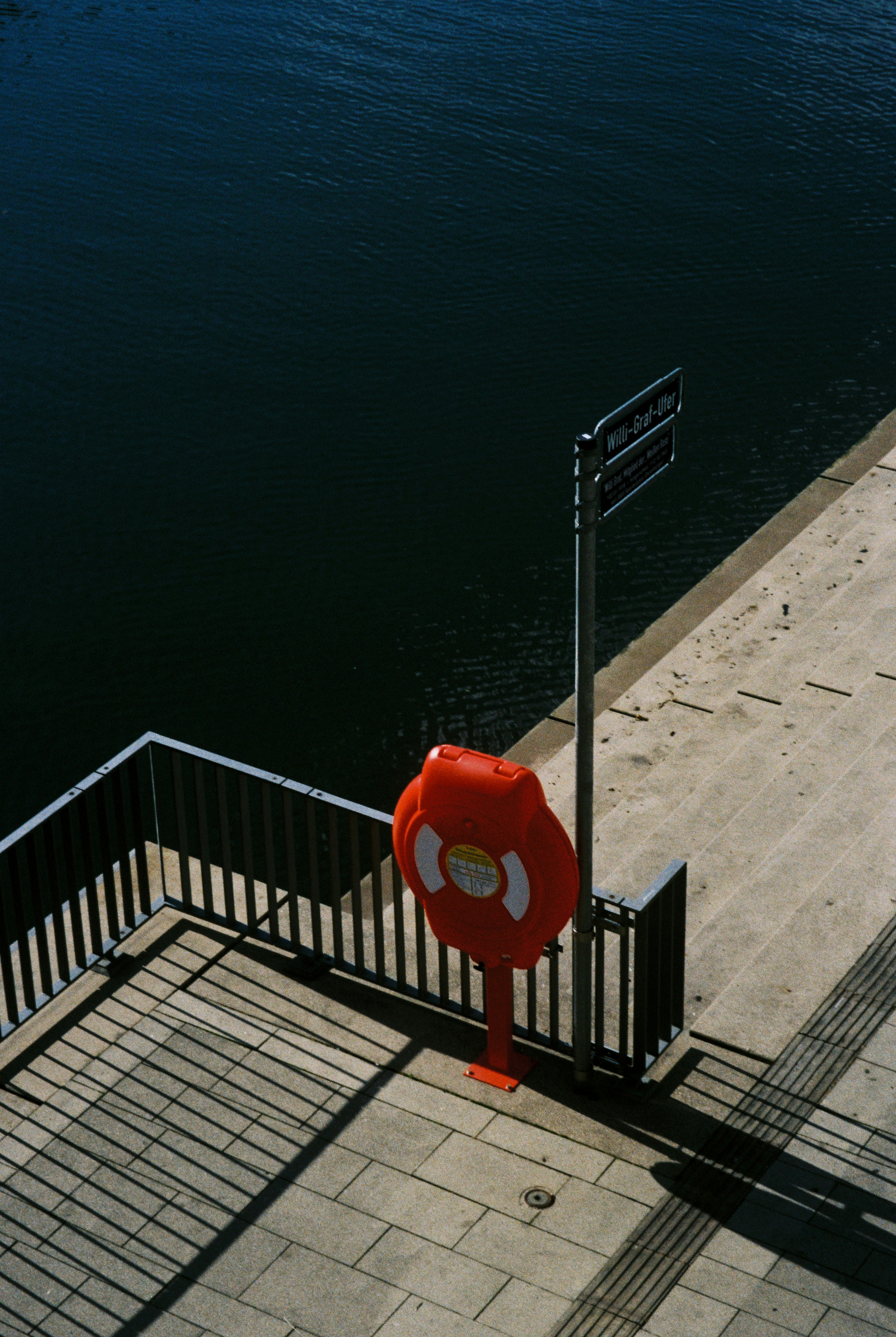 Shot on Kodak Gold 200 | A life preserver sits next to calm water.