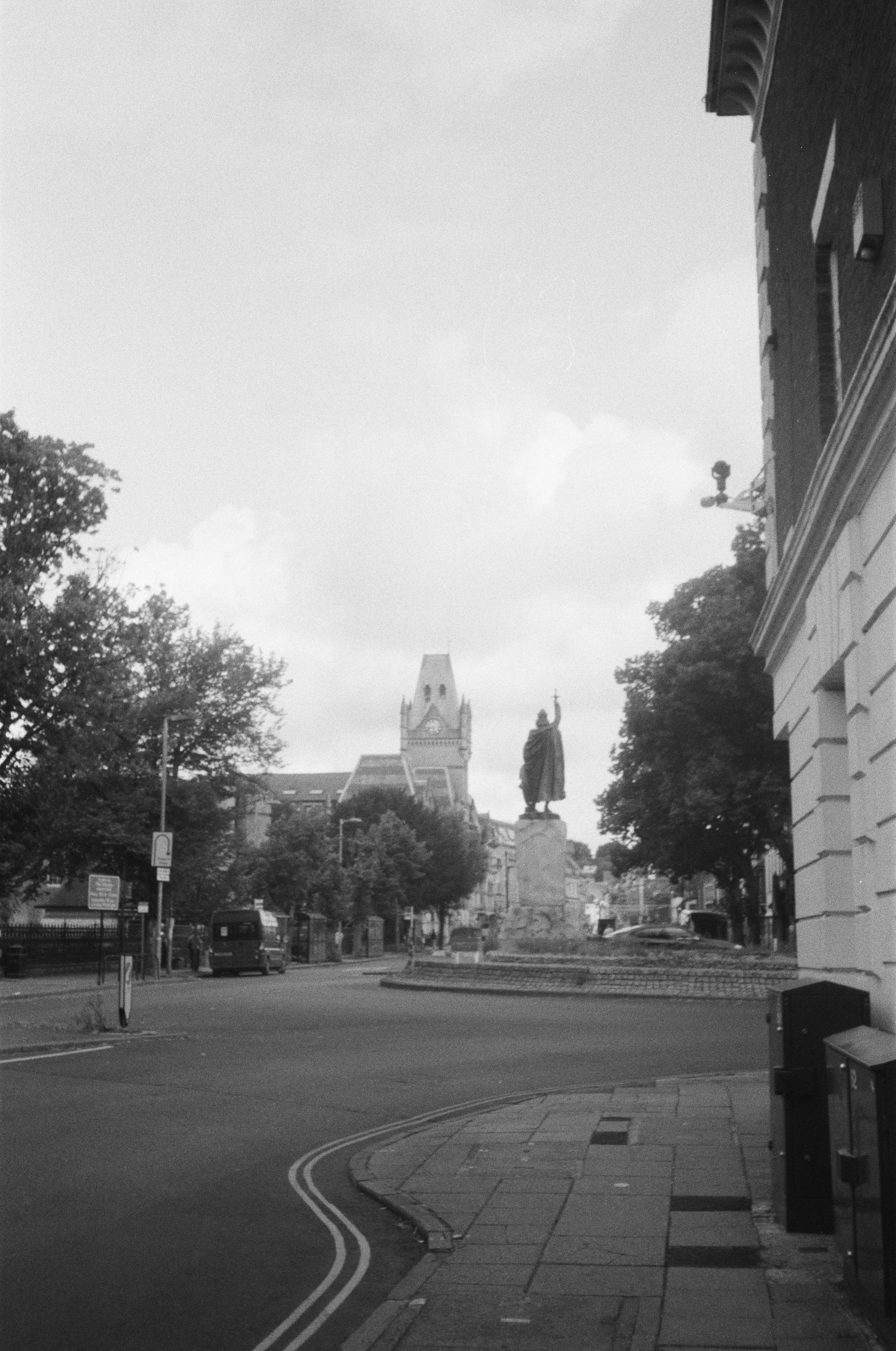 film photography, analog film shot, analogue photos, shot on film, film photo, 35mm, Ilford film, black and white photography, film is not dead | A statue stands at the center of a roundabout.