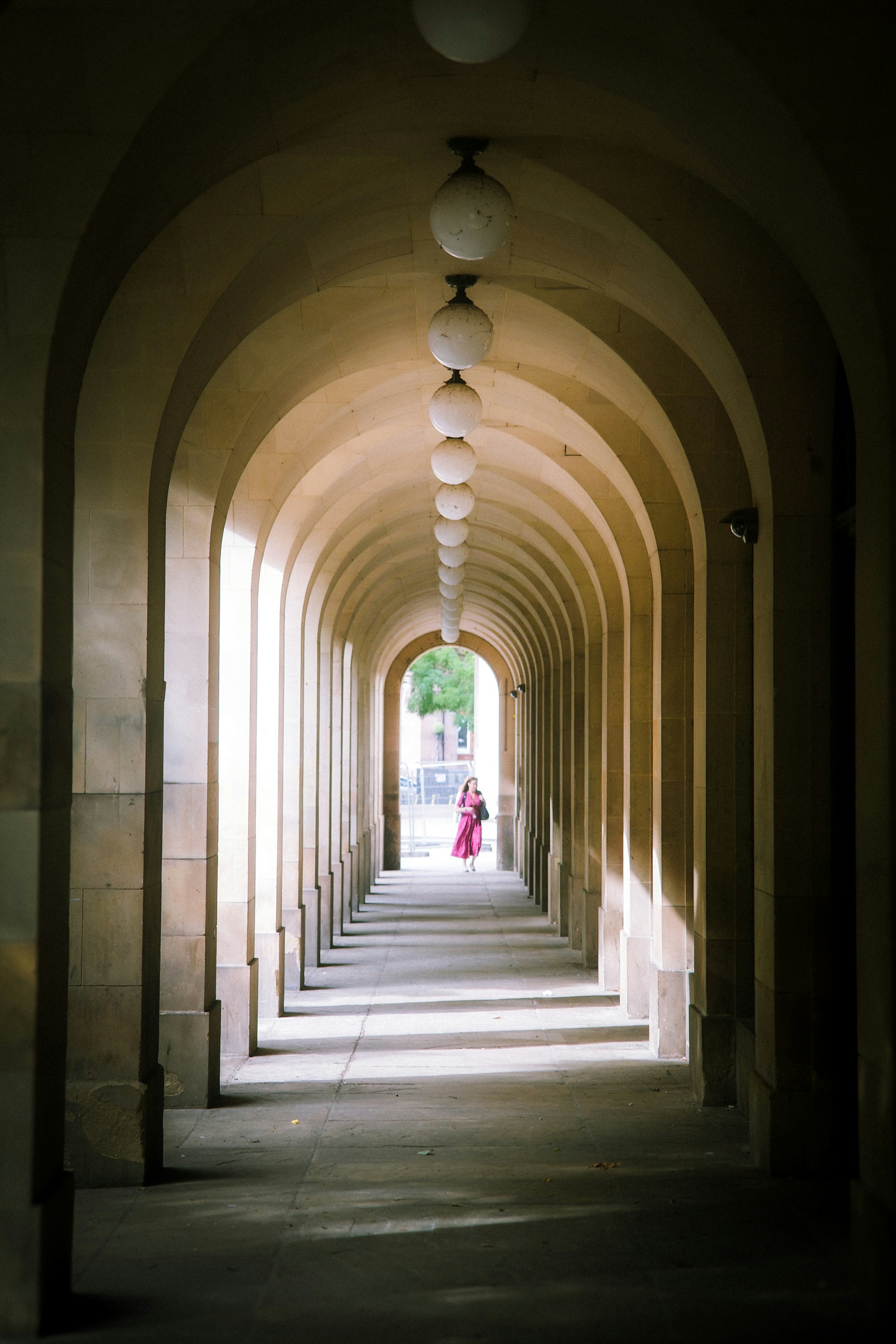 A long corridor with arches and hanging lights.