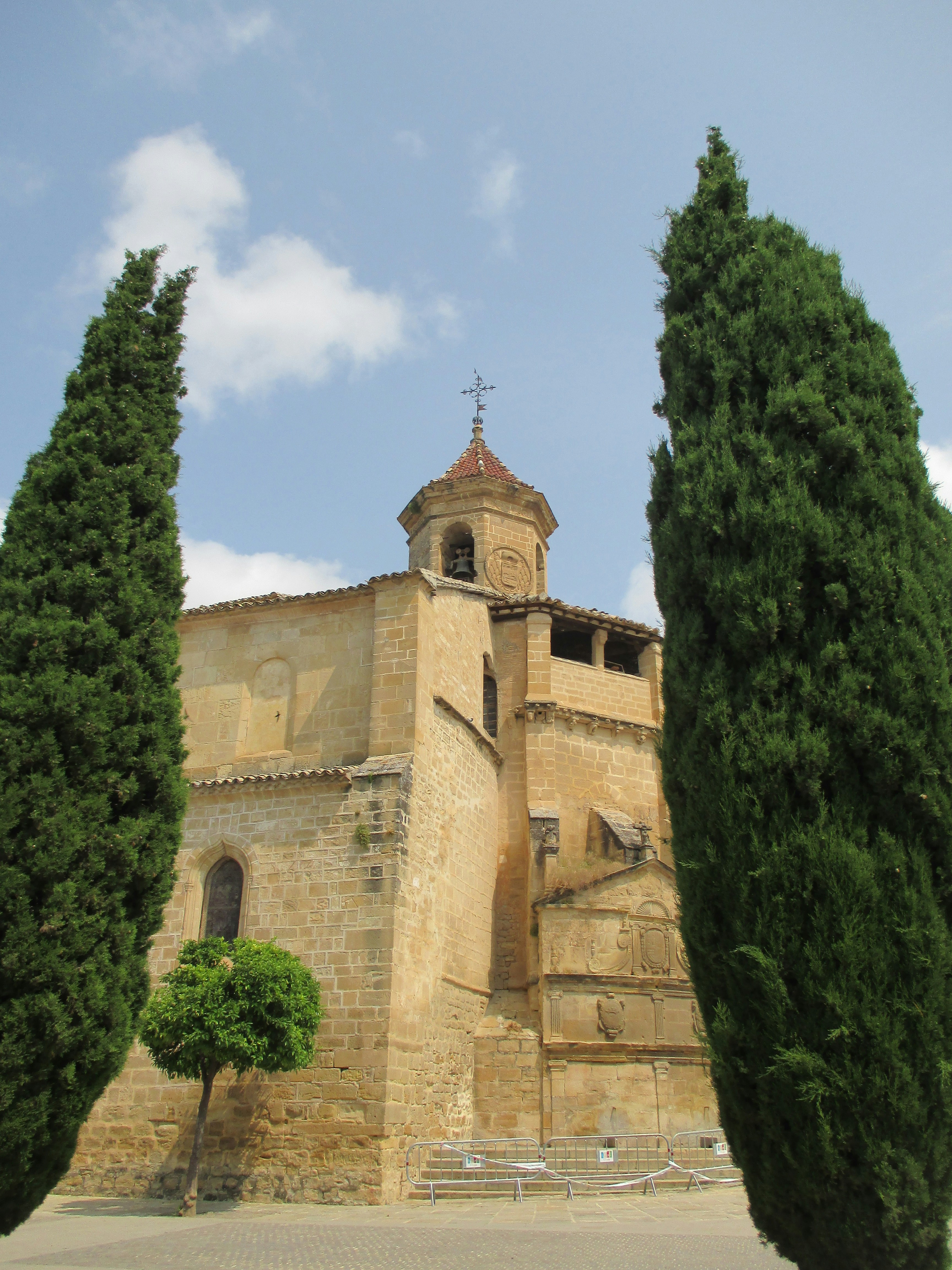 Church flanked by trees under a blue sky.