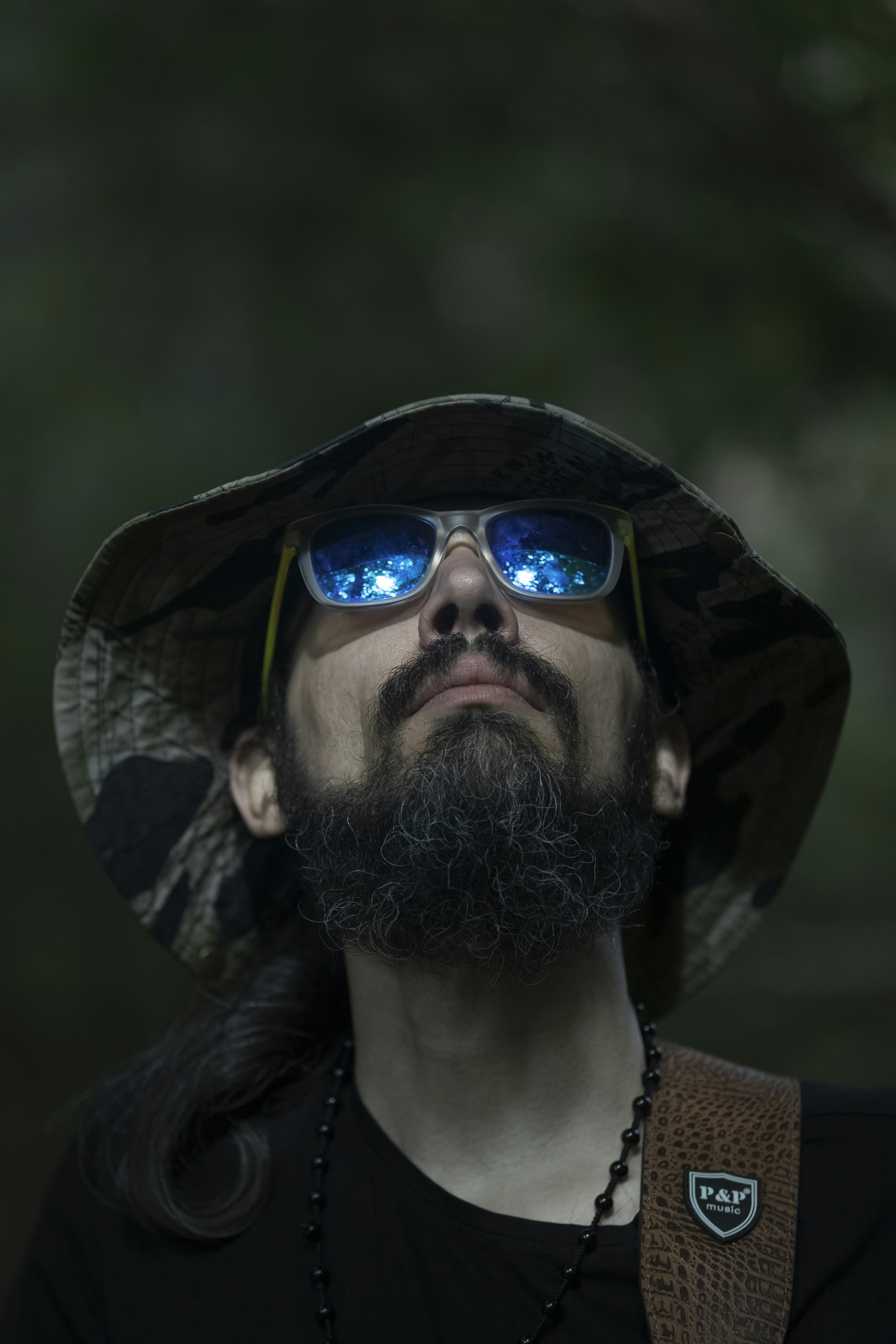 Man looks upward with reflections in his sunglasses.
