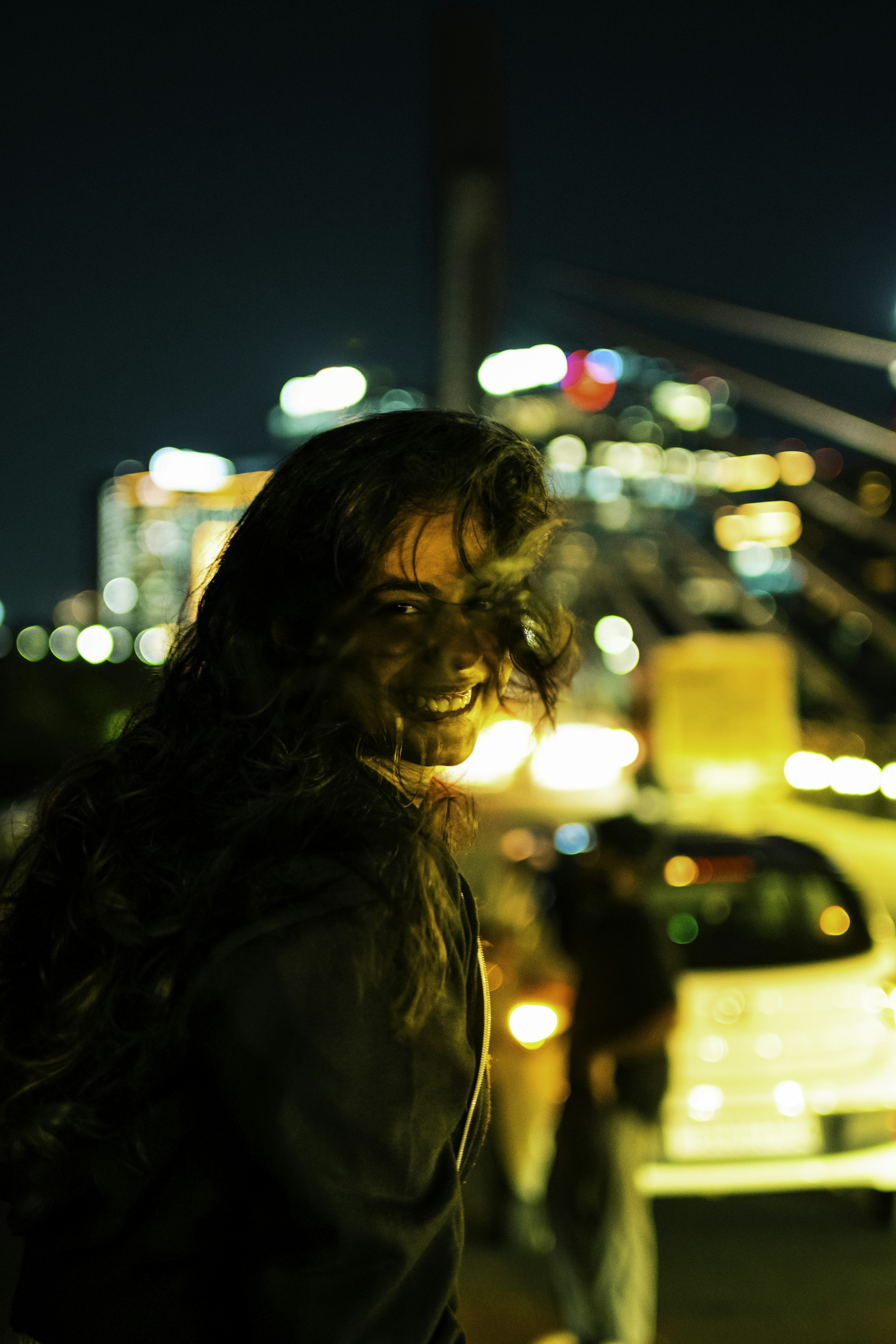 Women poses on the cable bridge at Durgam Cheruvu, Hyderabad | Woman smiles brightly in the night city.