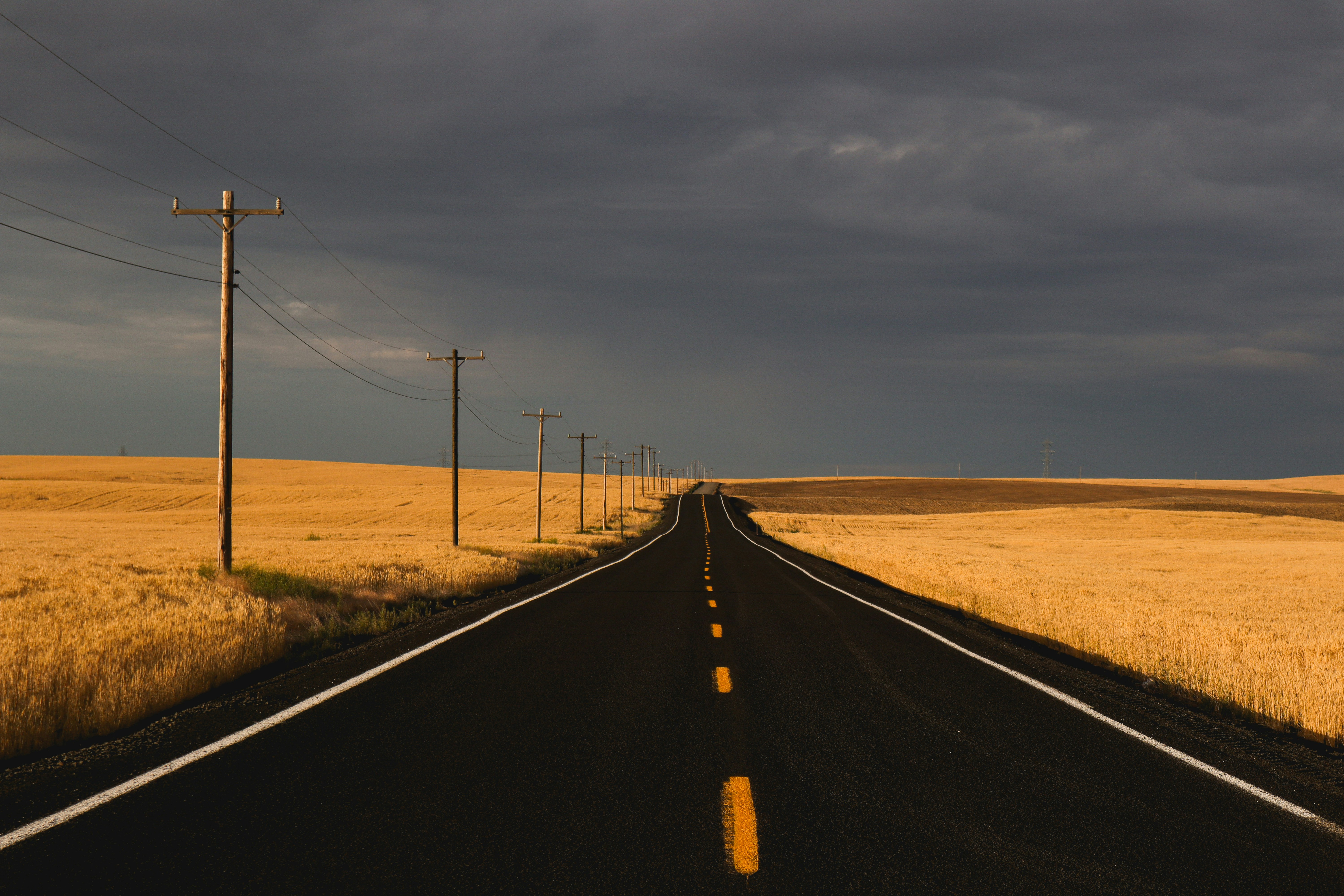 Sweet country road | A road stretches into the distance under a cloudy sky.