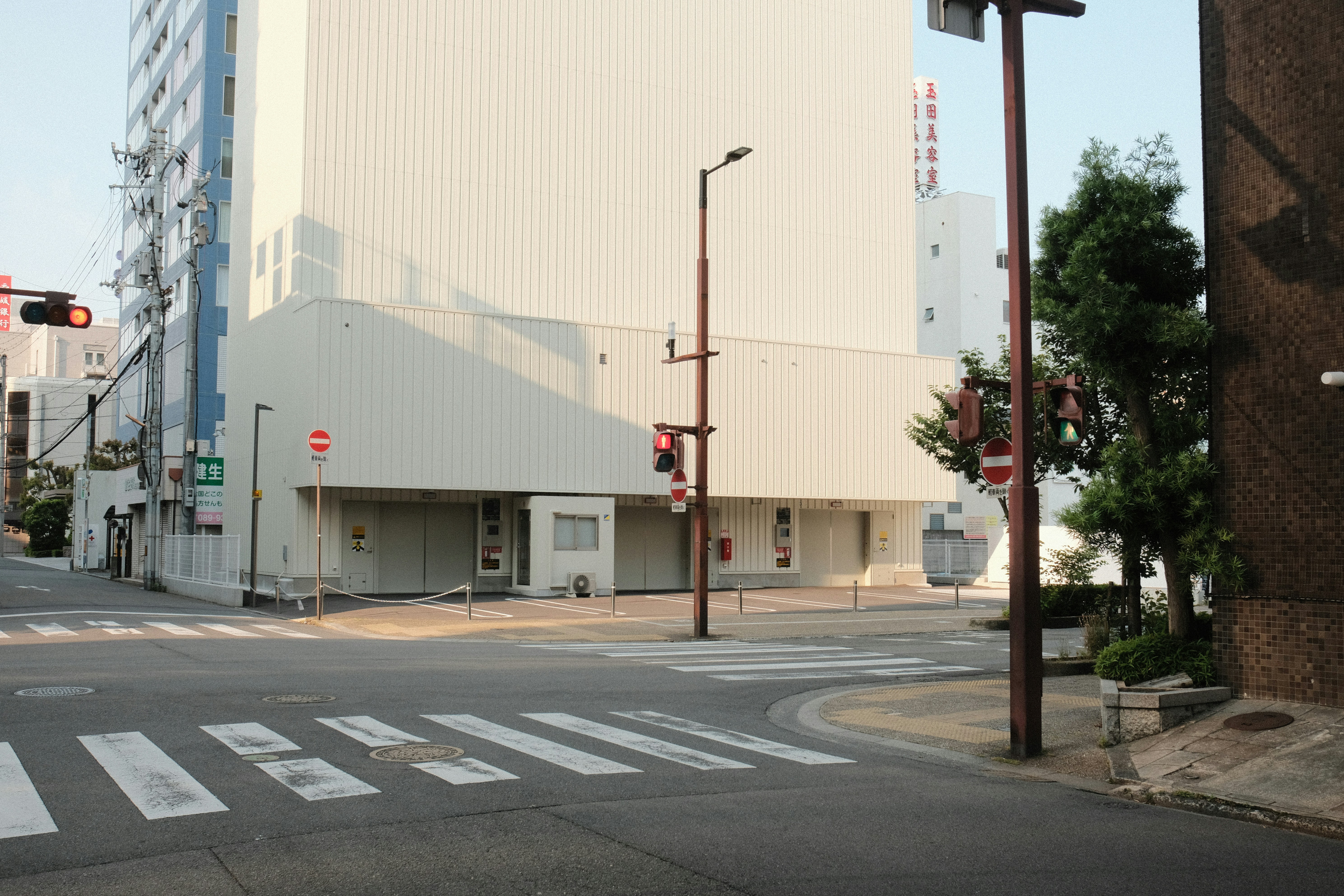A street intersection with a large white building. photo – Free Street ...