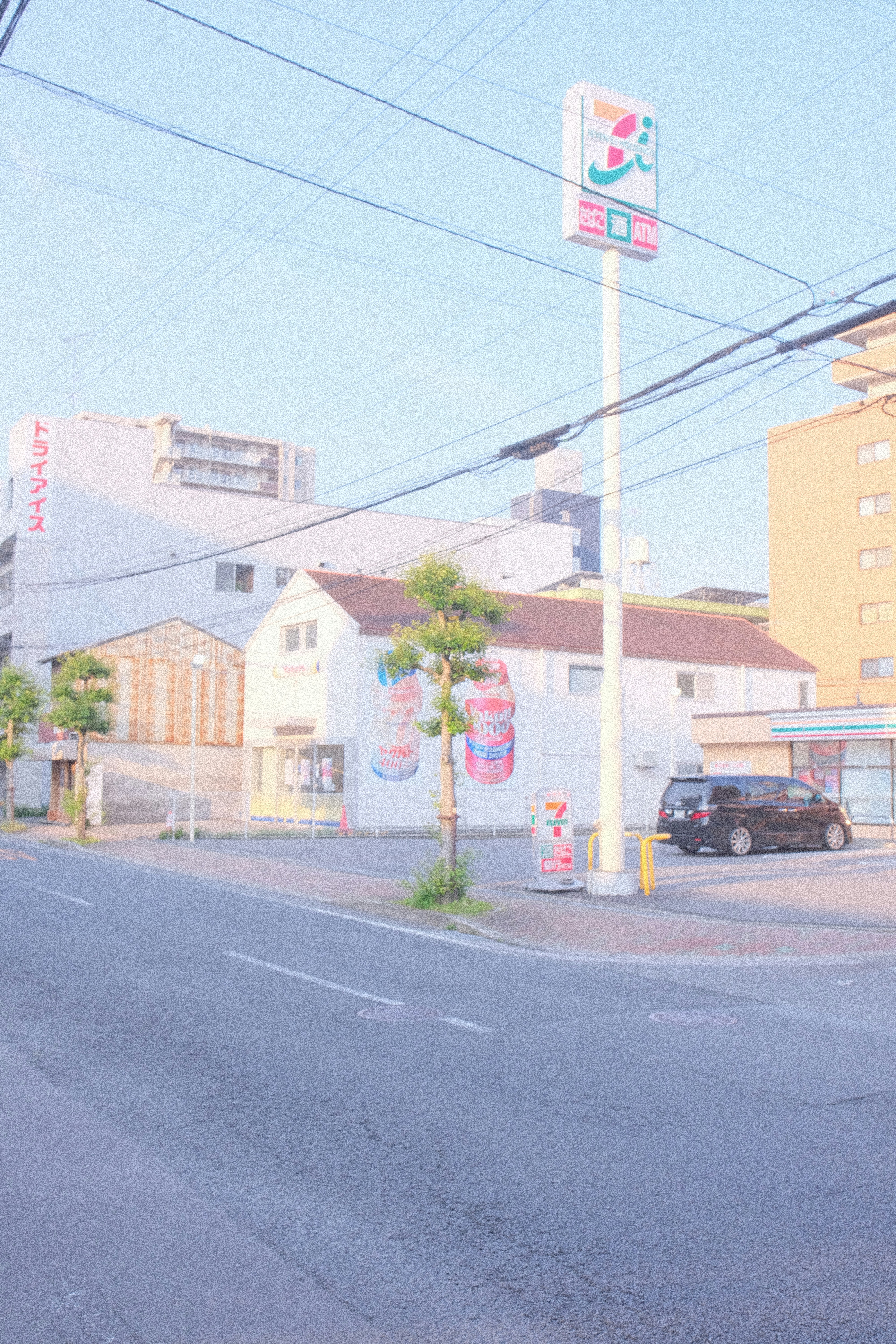 A japanese convenience store on a sunny street.