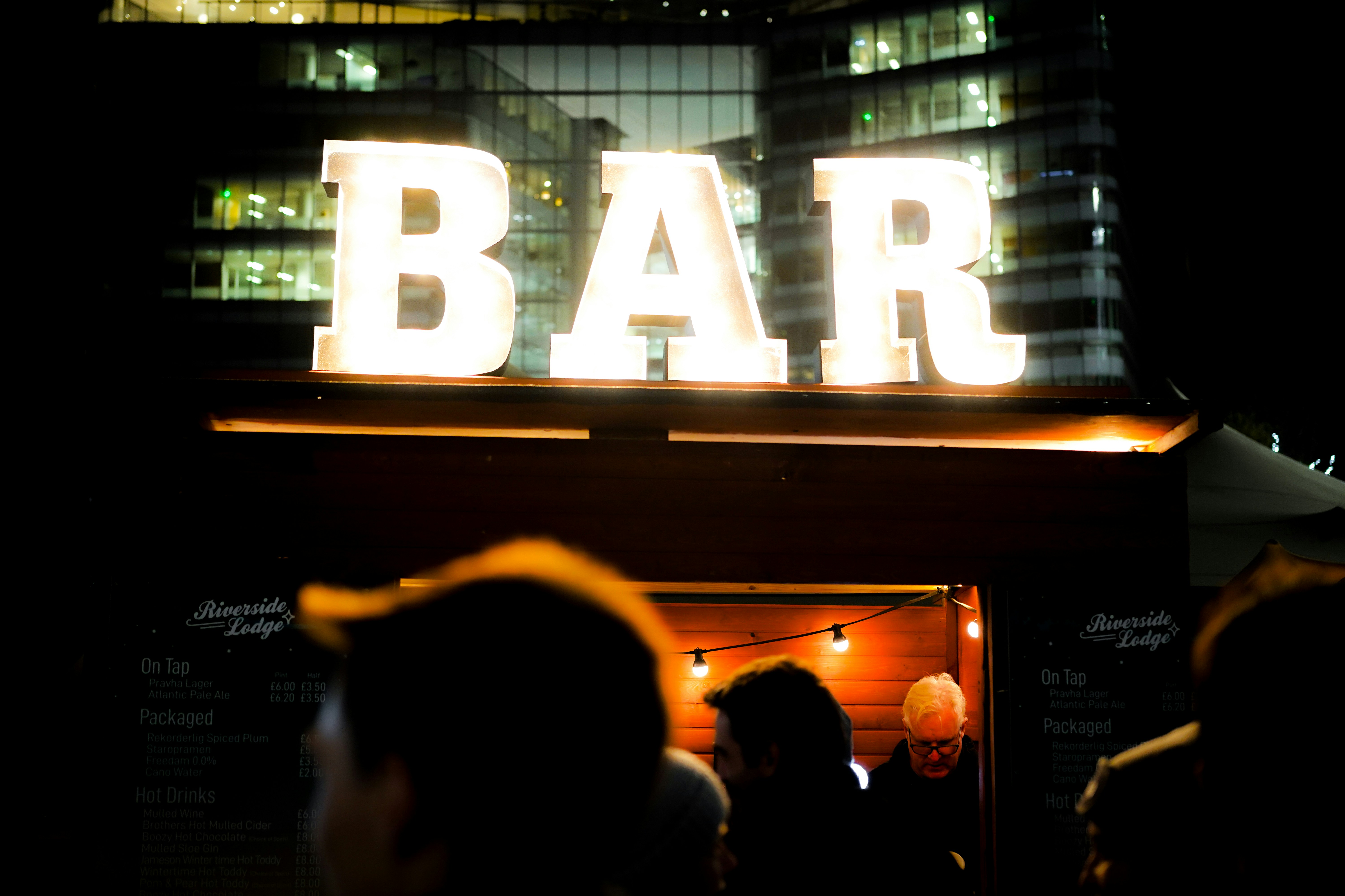 A bar sign lights up brightly at night.