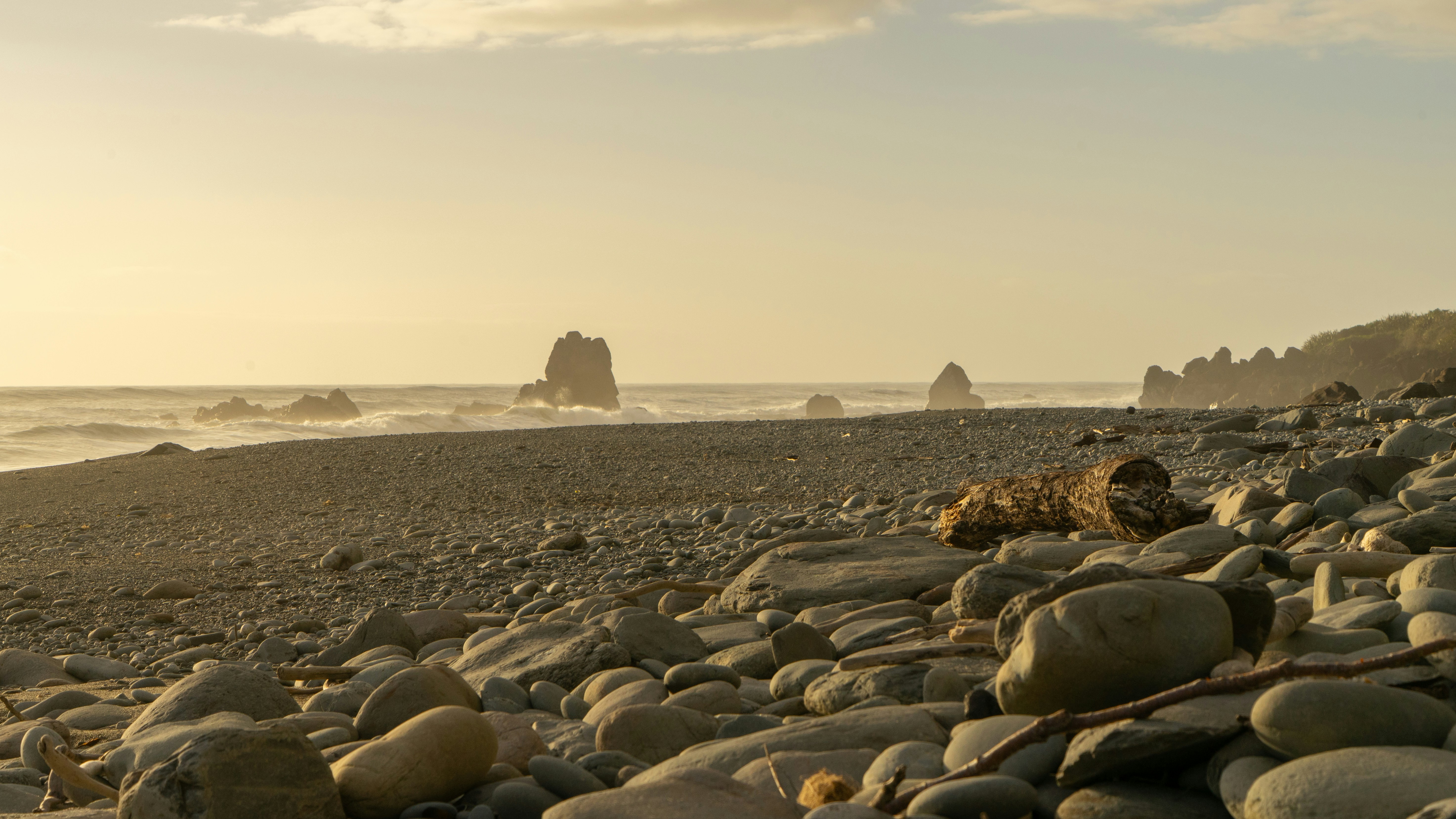 Rocky beach under a golden, sunset sky.
