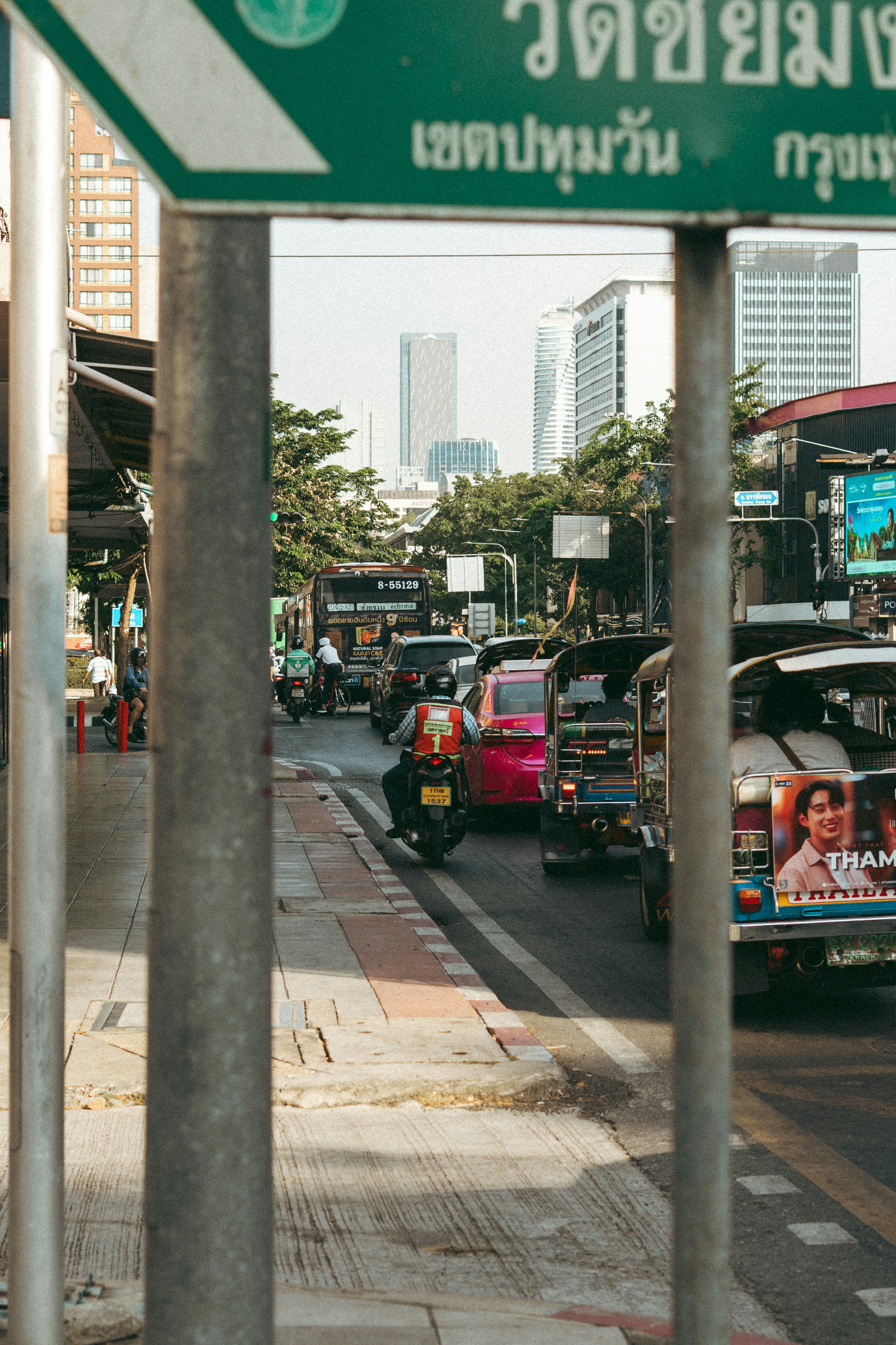 Busy bangkok street scene, framed by a pole.