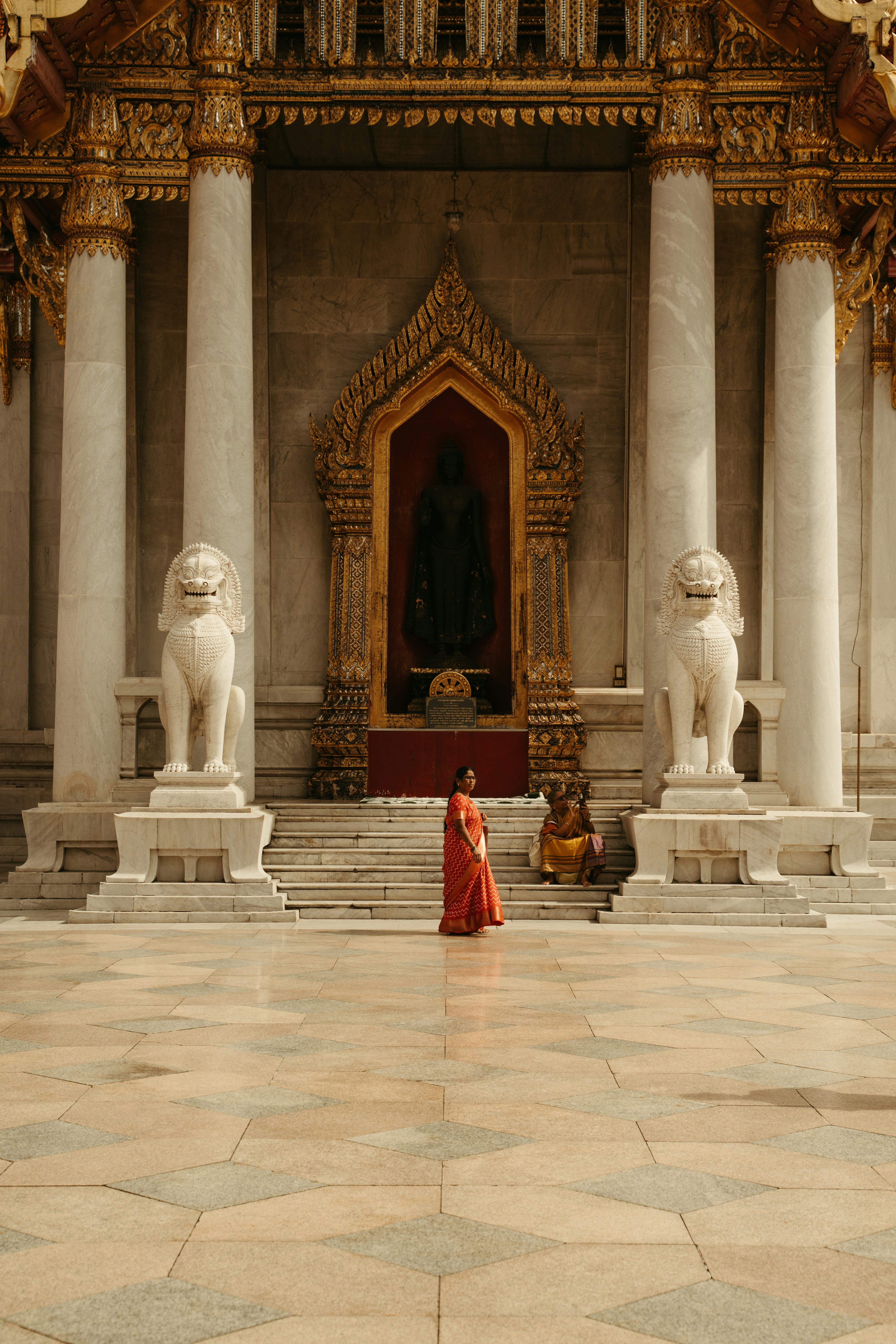 A woman stands before a beautiful temple.