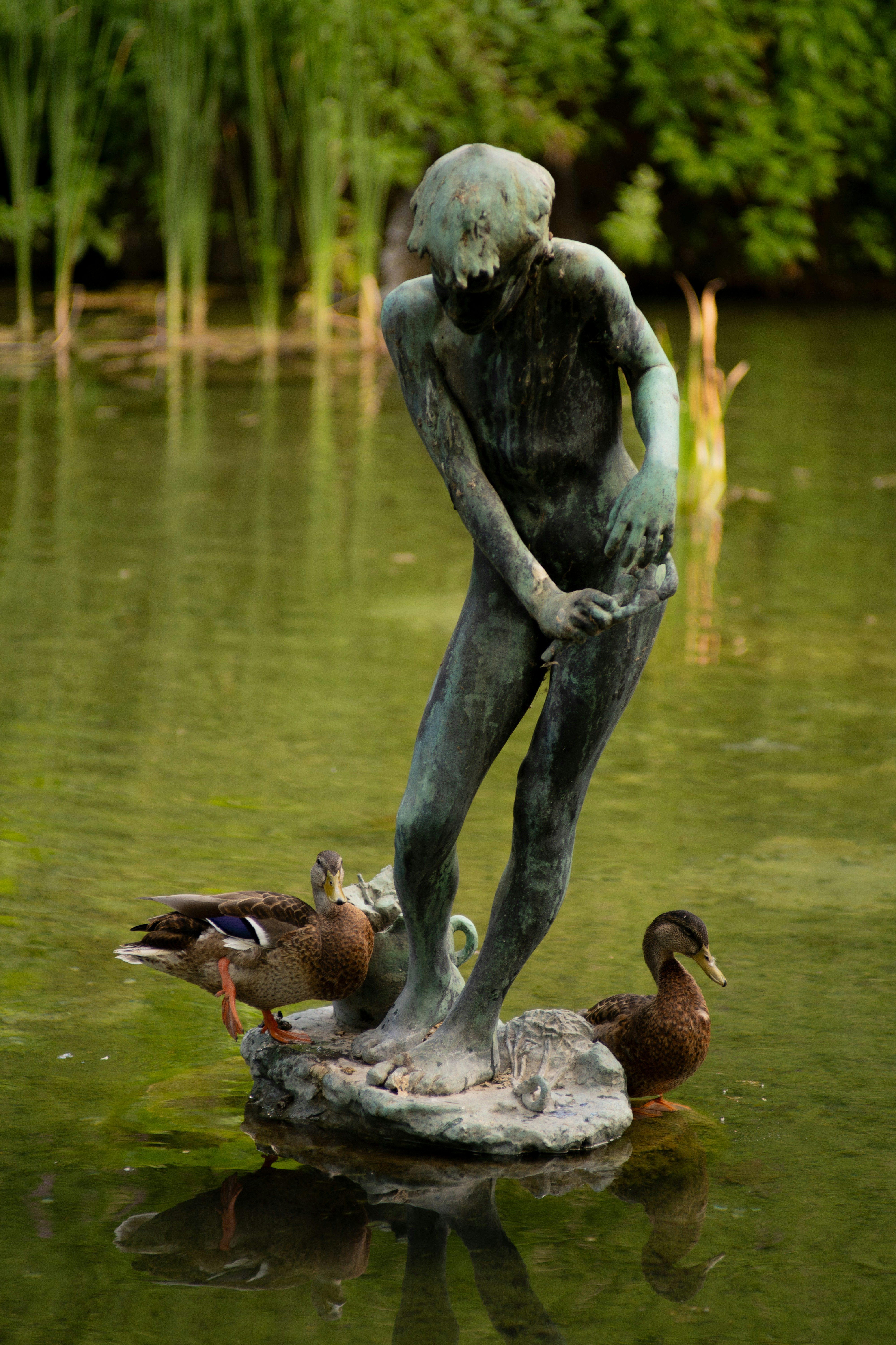 Japanese garden sculpture in Budapest | A statue of a boy and ducks in a pond.