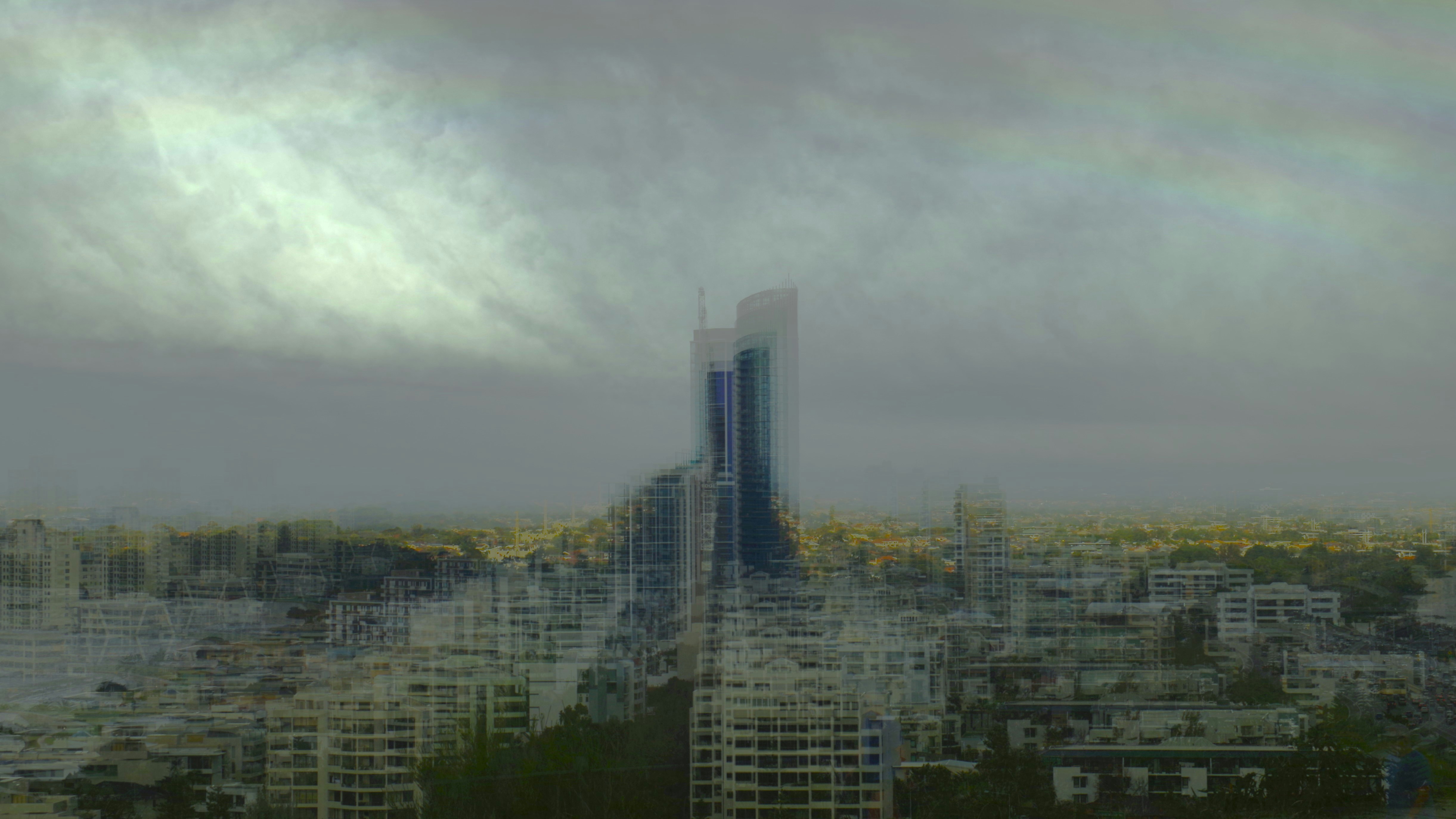 A multi exposure image of a city skyline | Blurry cityscape under cloudy sky.