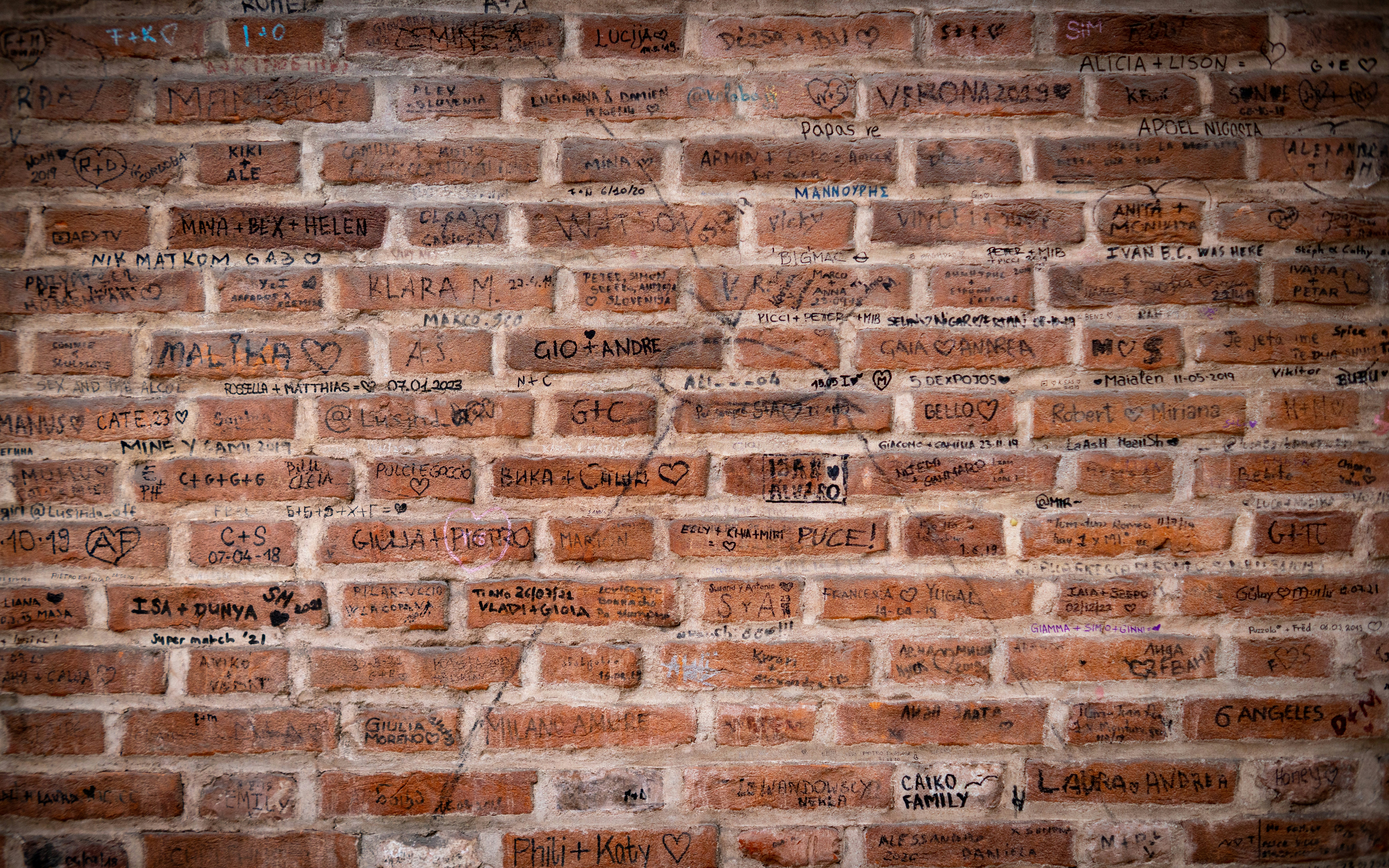 Red brick wall with writing marks.