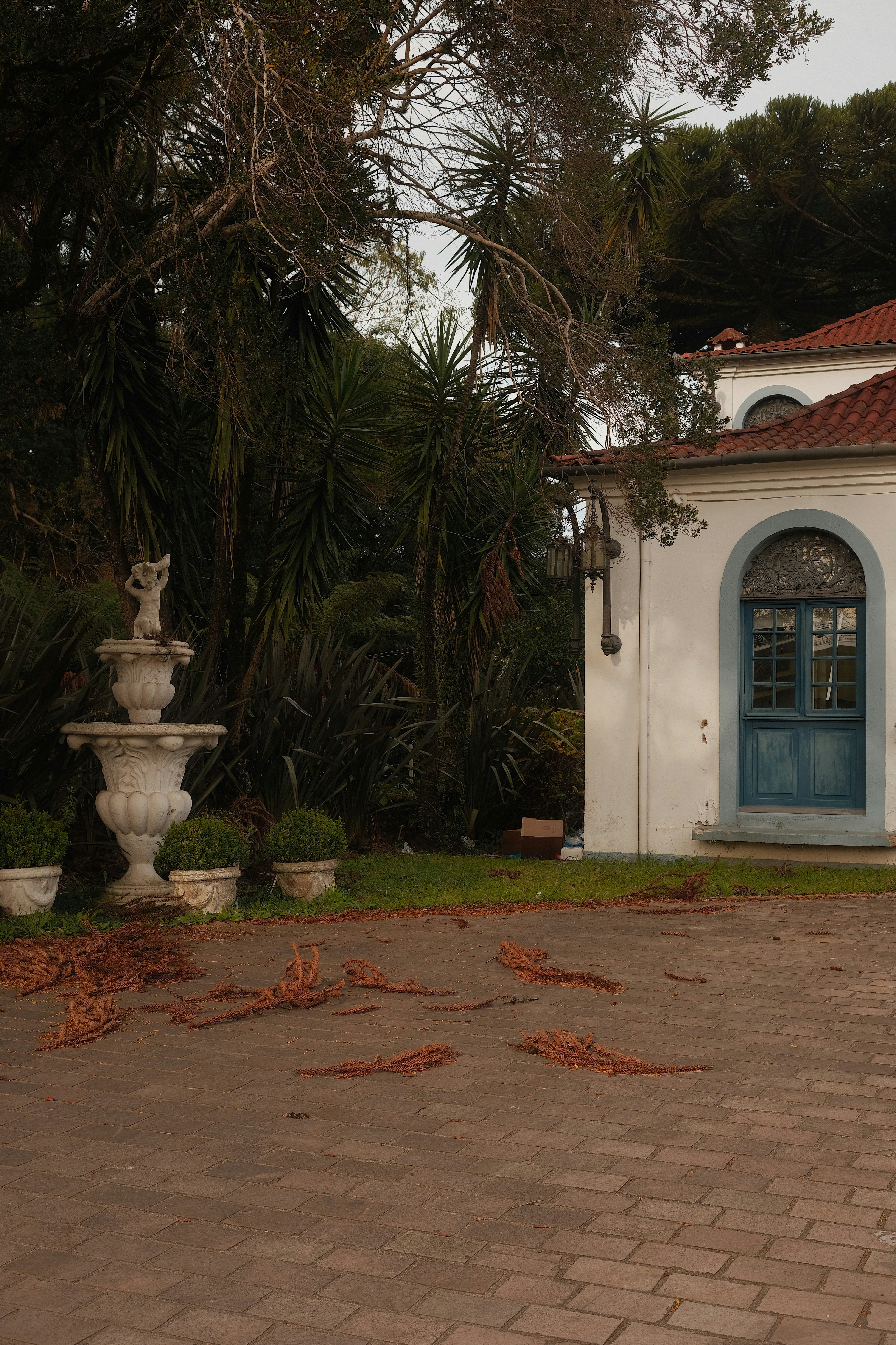 Casa antiga, Canela, RS. | An old, white building with a fountain.