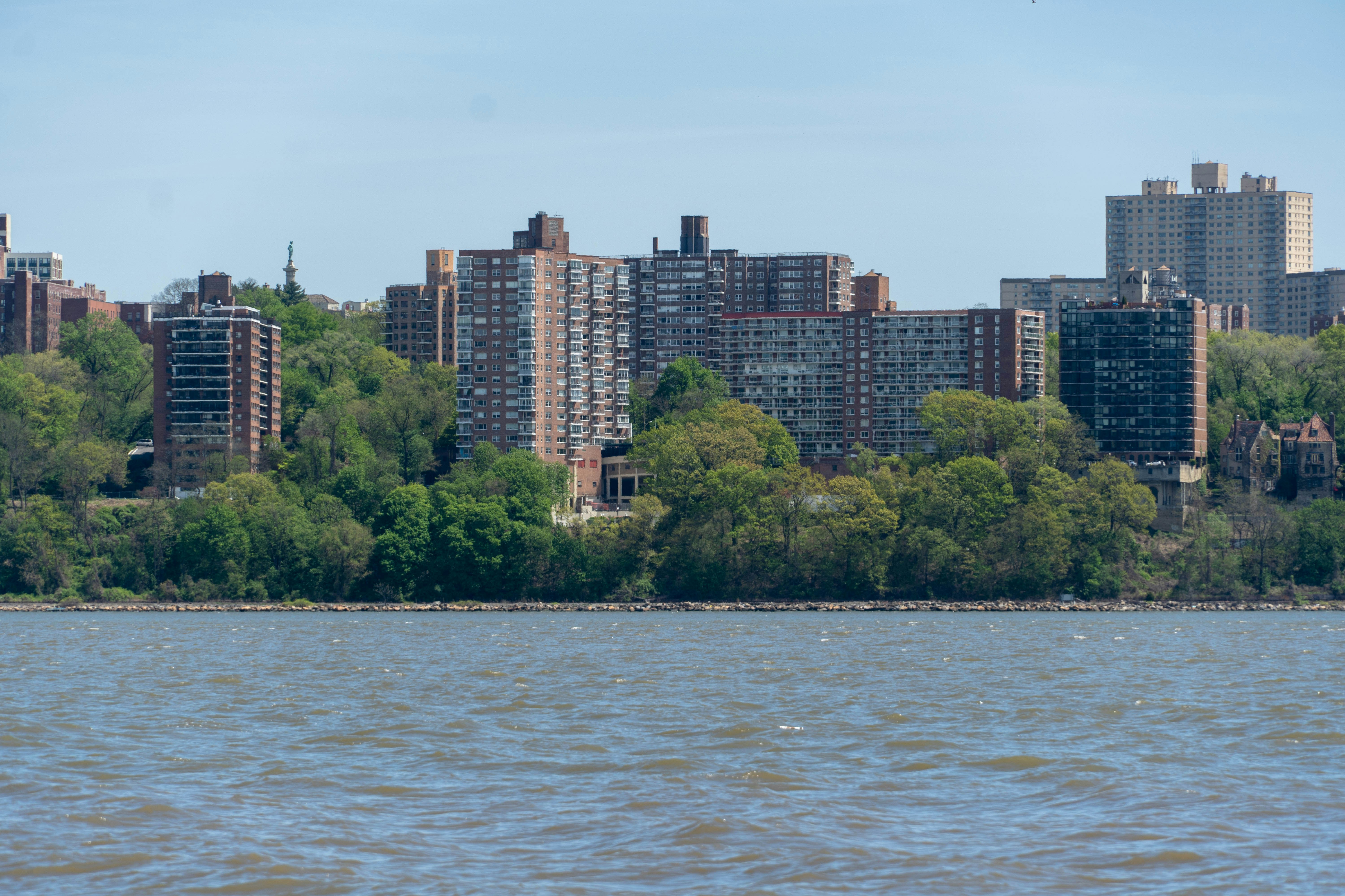 Distant city skyline reflecting on the water.