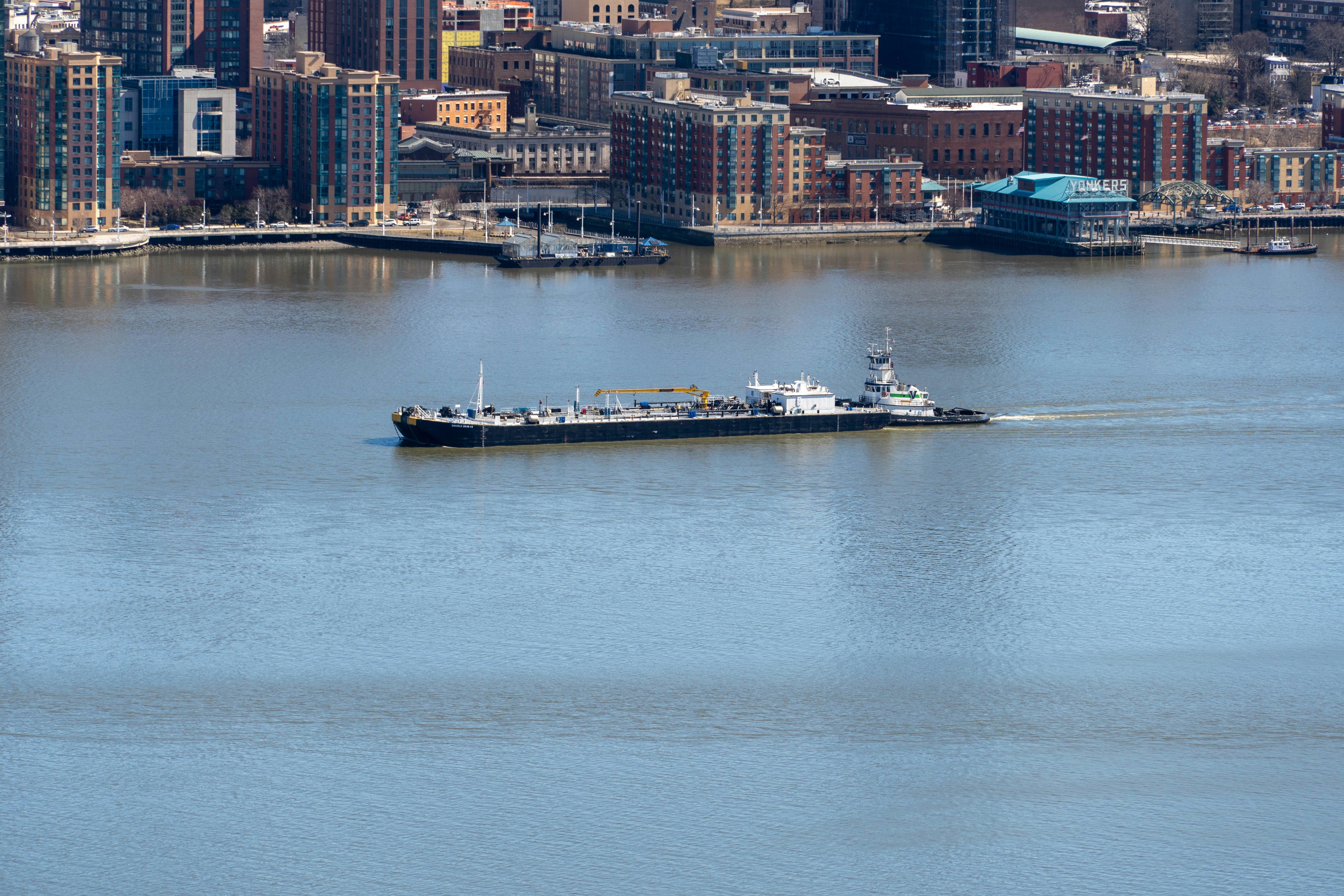 A boat sails on the water near a city.