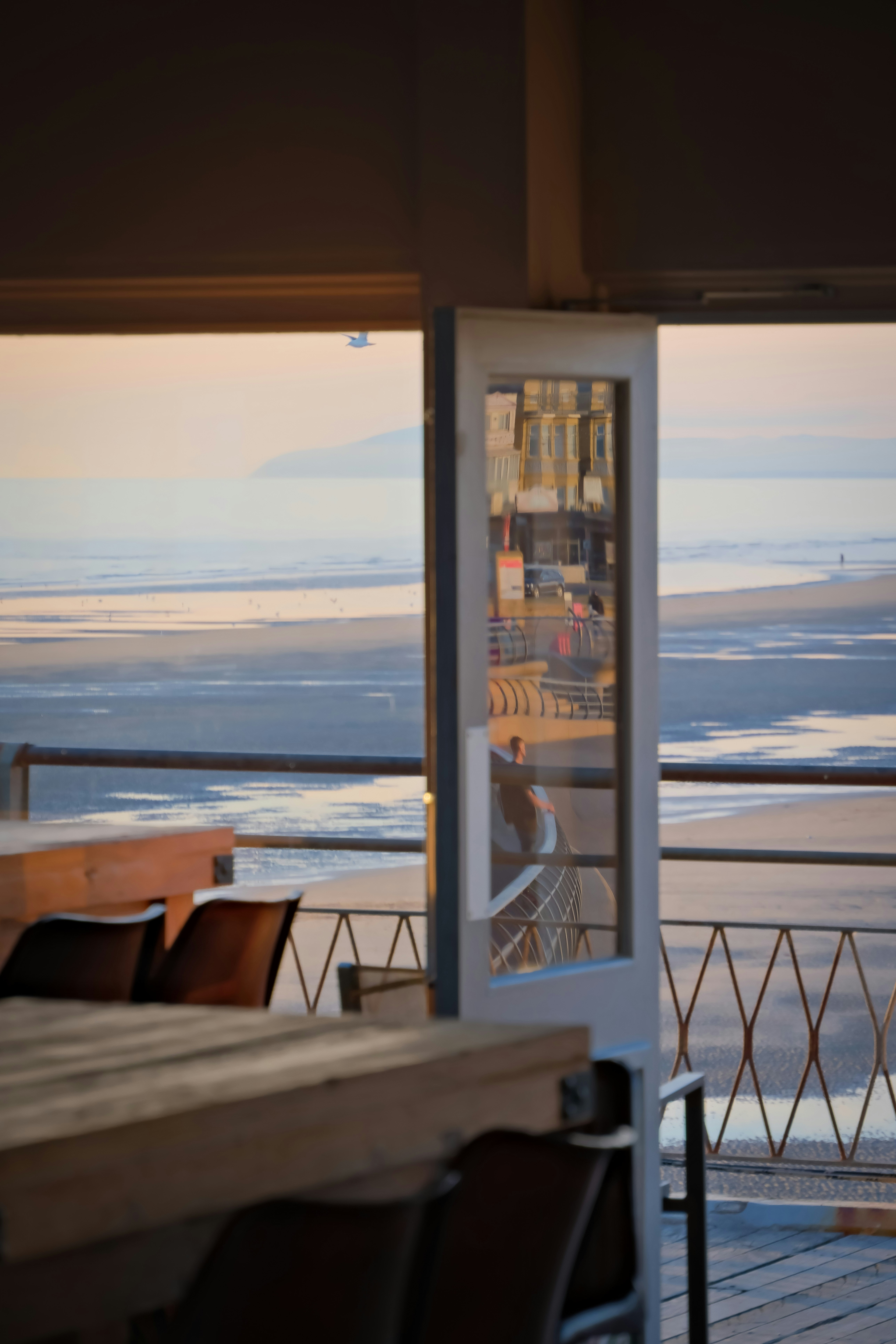 A beach view reflected in a door.