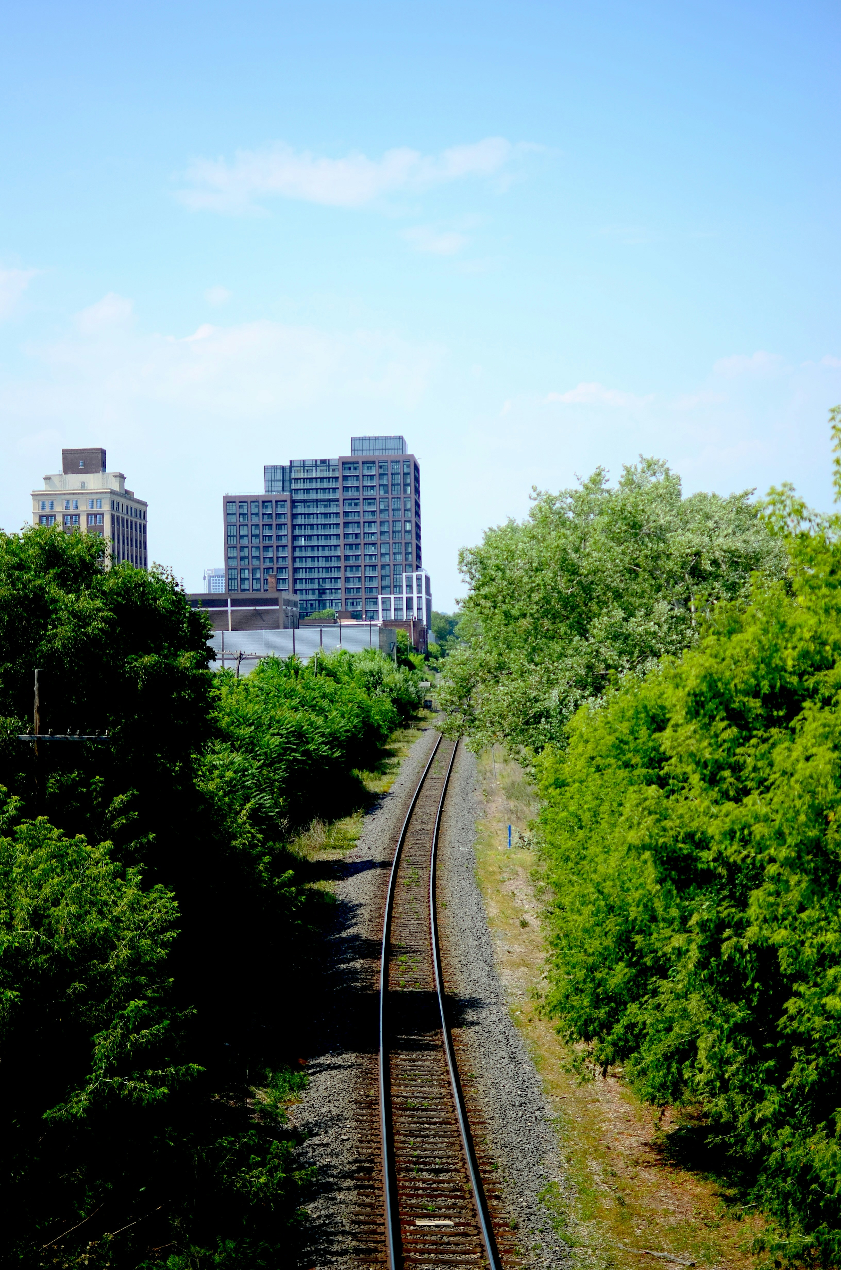 Train tracks lead to a city skyline.
