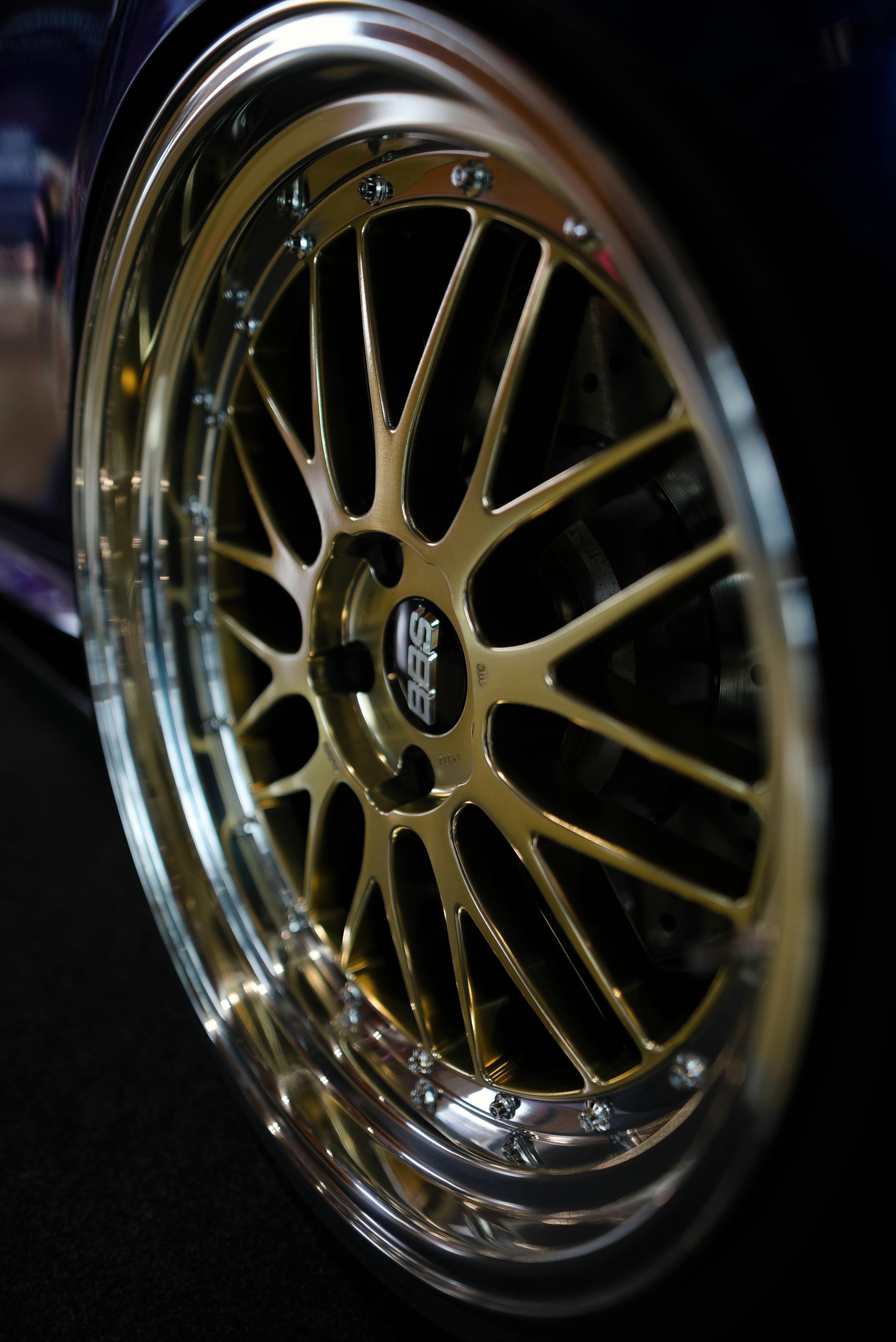 taken at ps days | A shiny gold car wheel is shown.