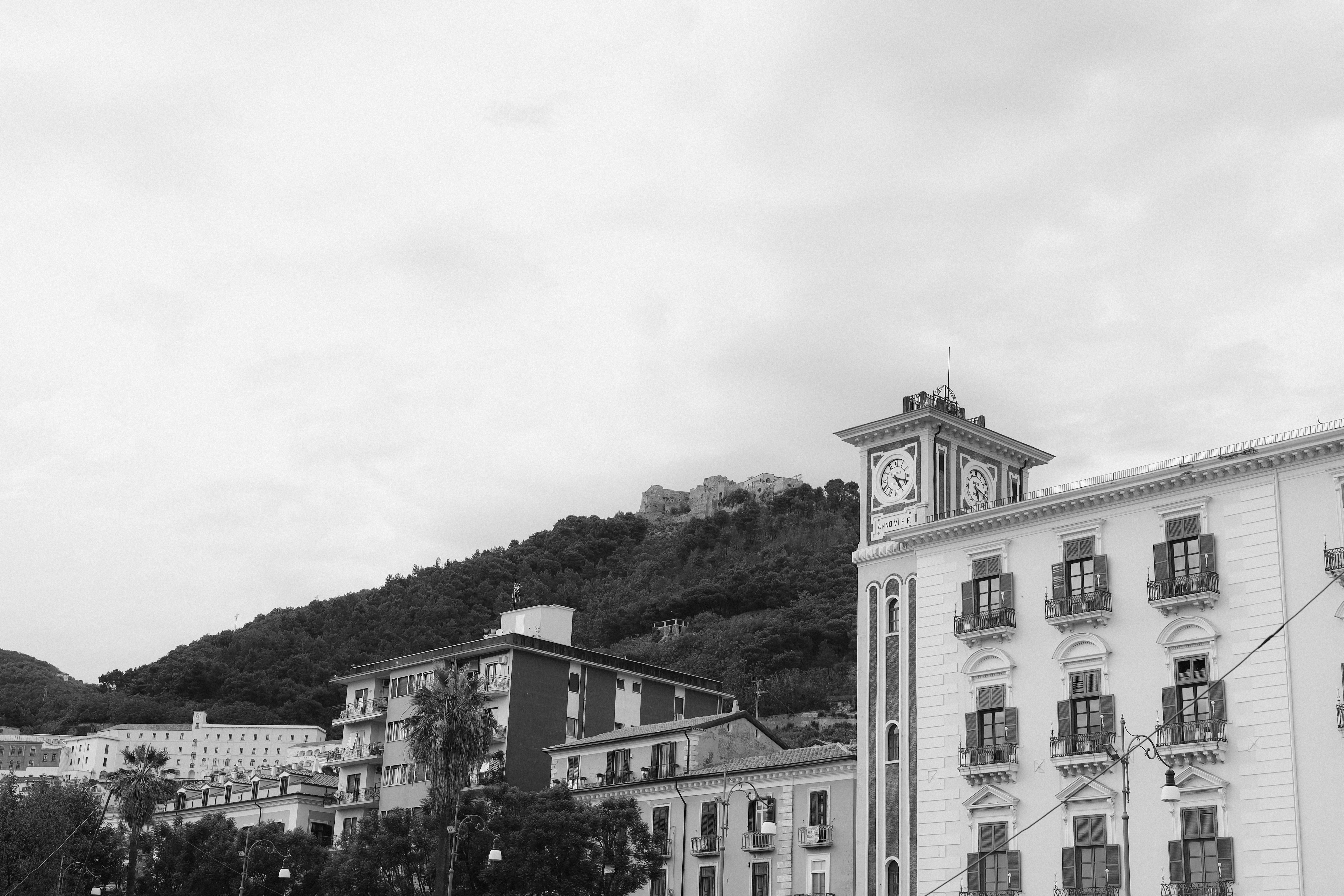 Buildings stand beneath a cloudy sky.