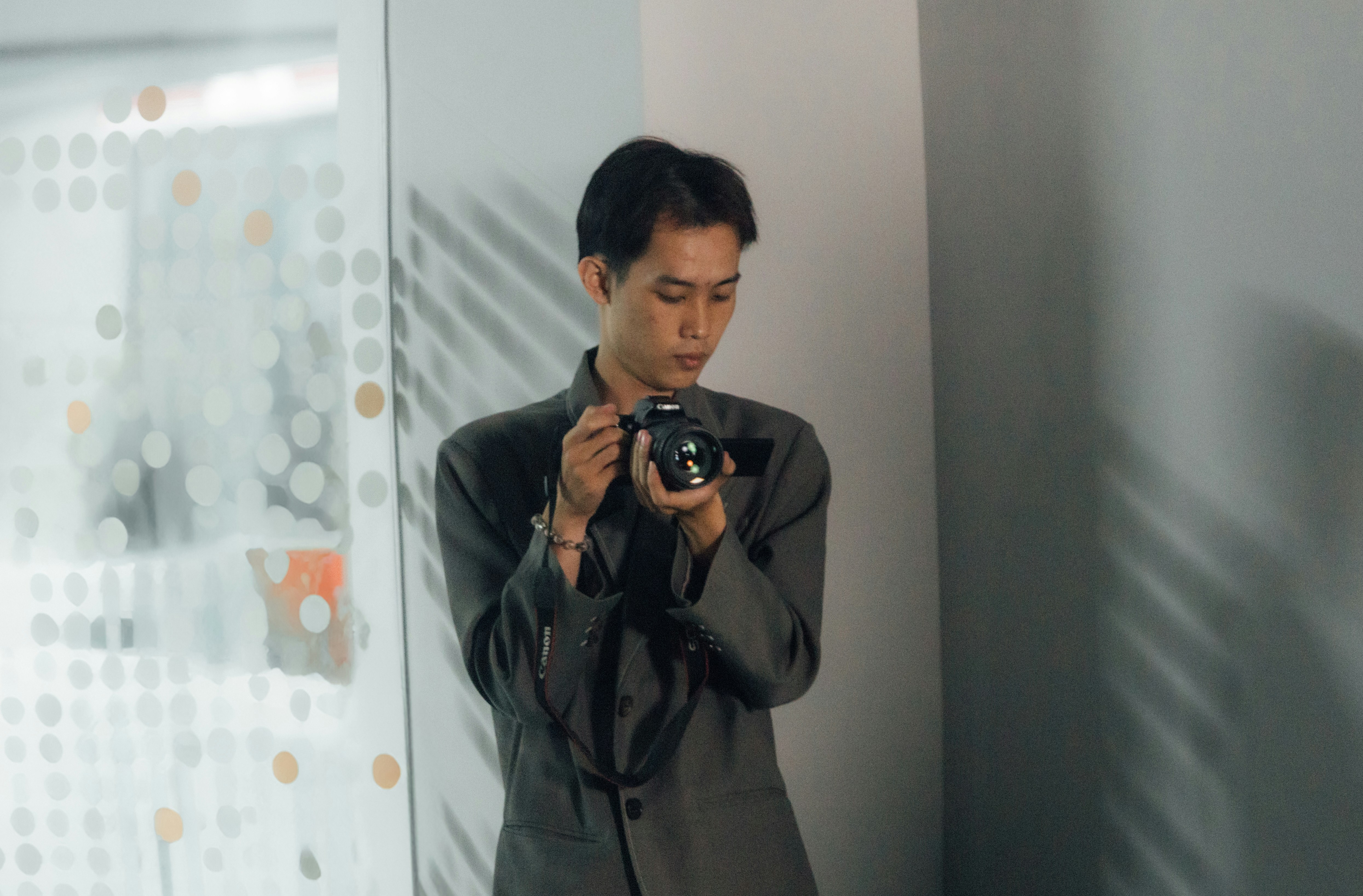 A man holds a camera and examines it.