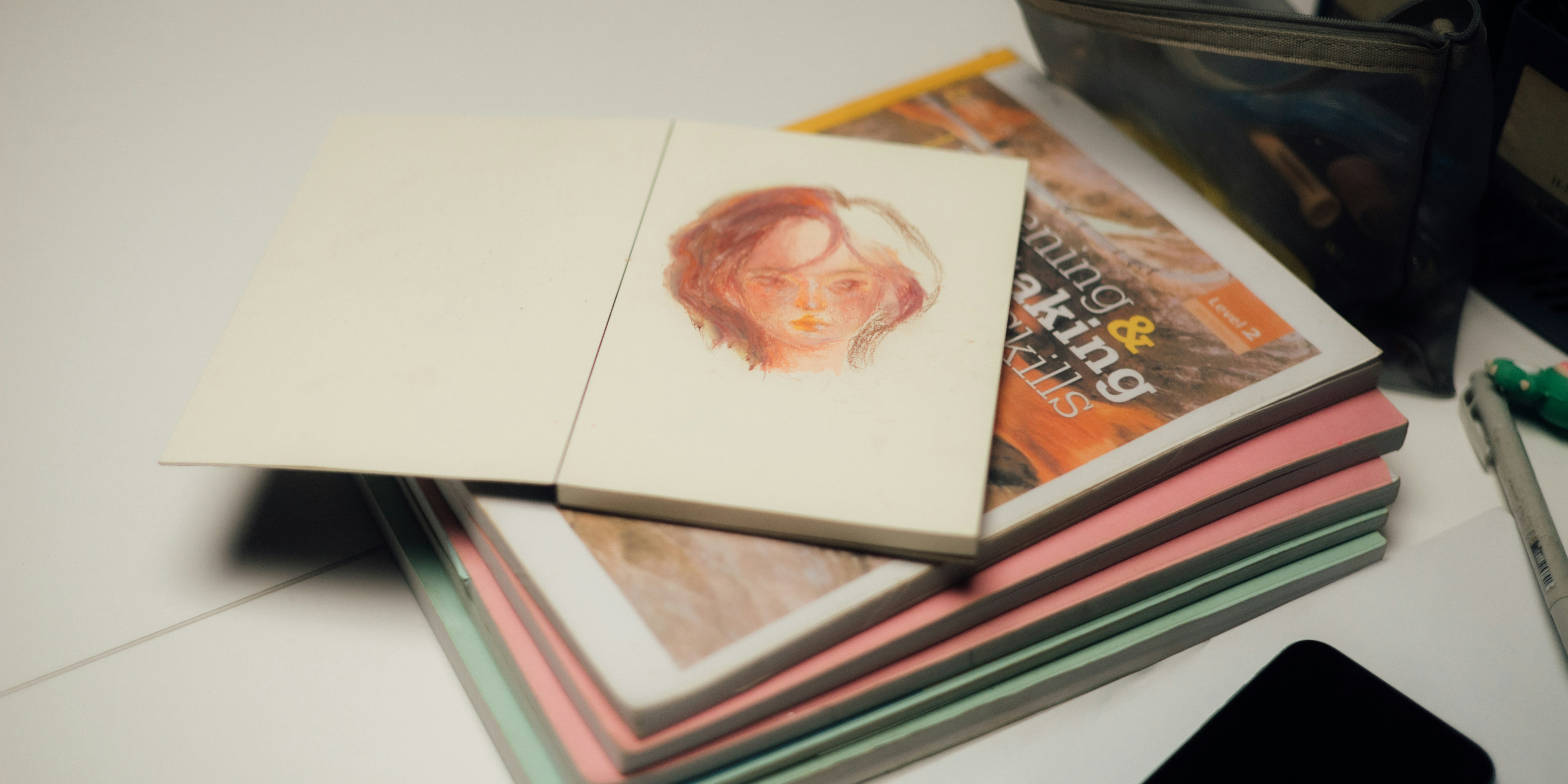 A book is open with a portrait on top.