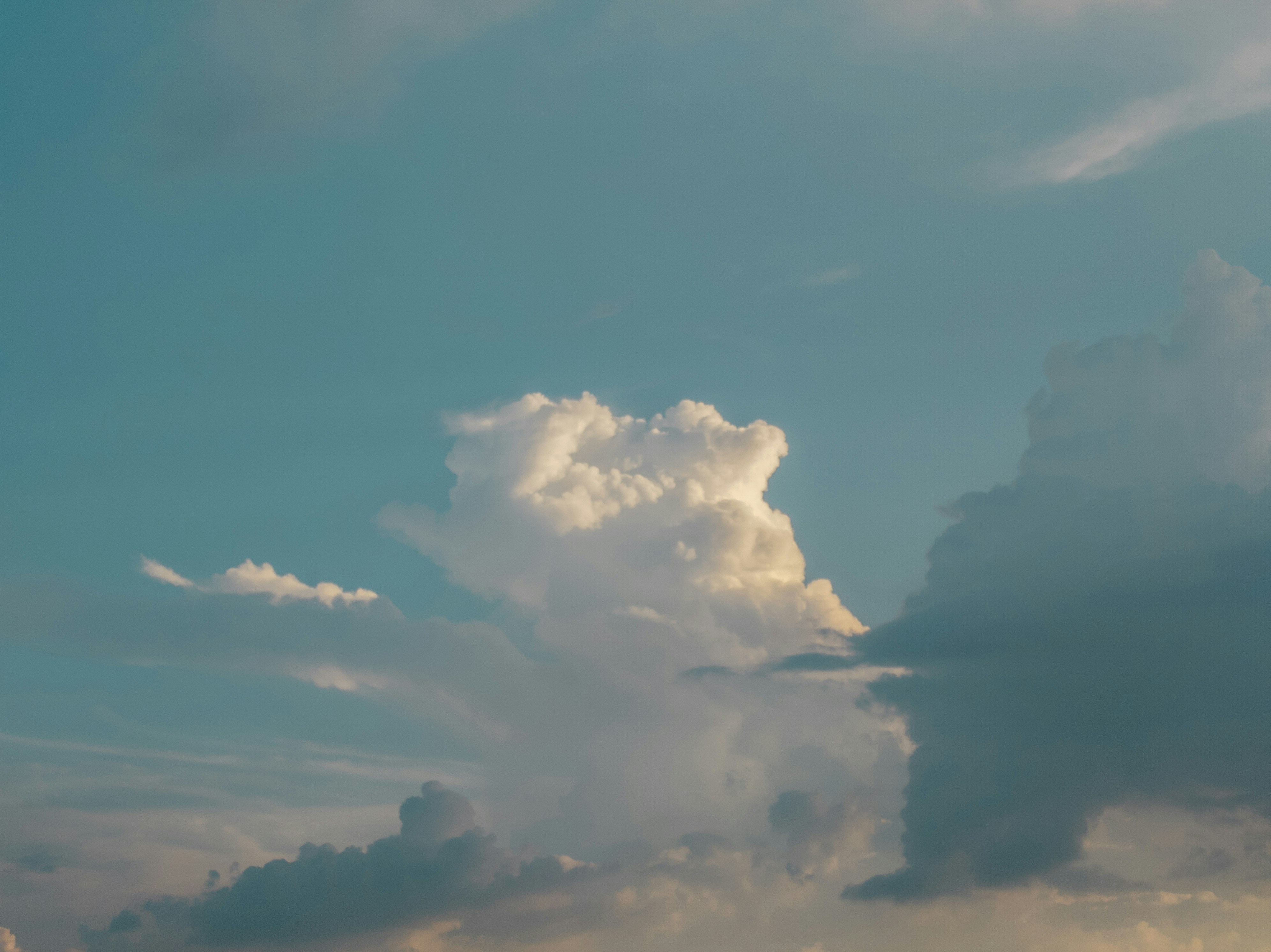 Fluffy clouds drift against a blue sky.