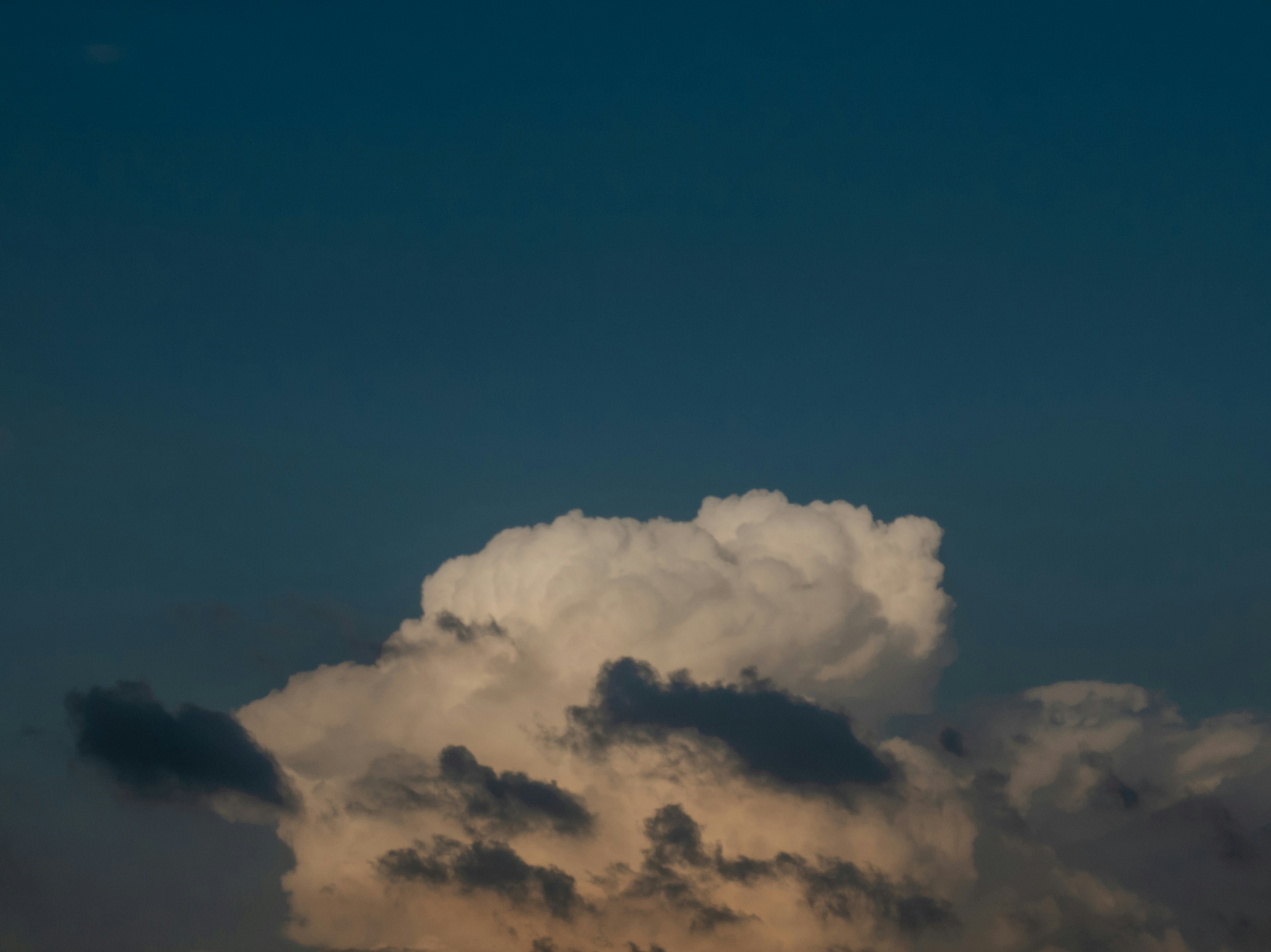 A cumulus cloud dominates the serene blue sky.