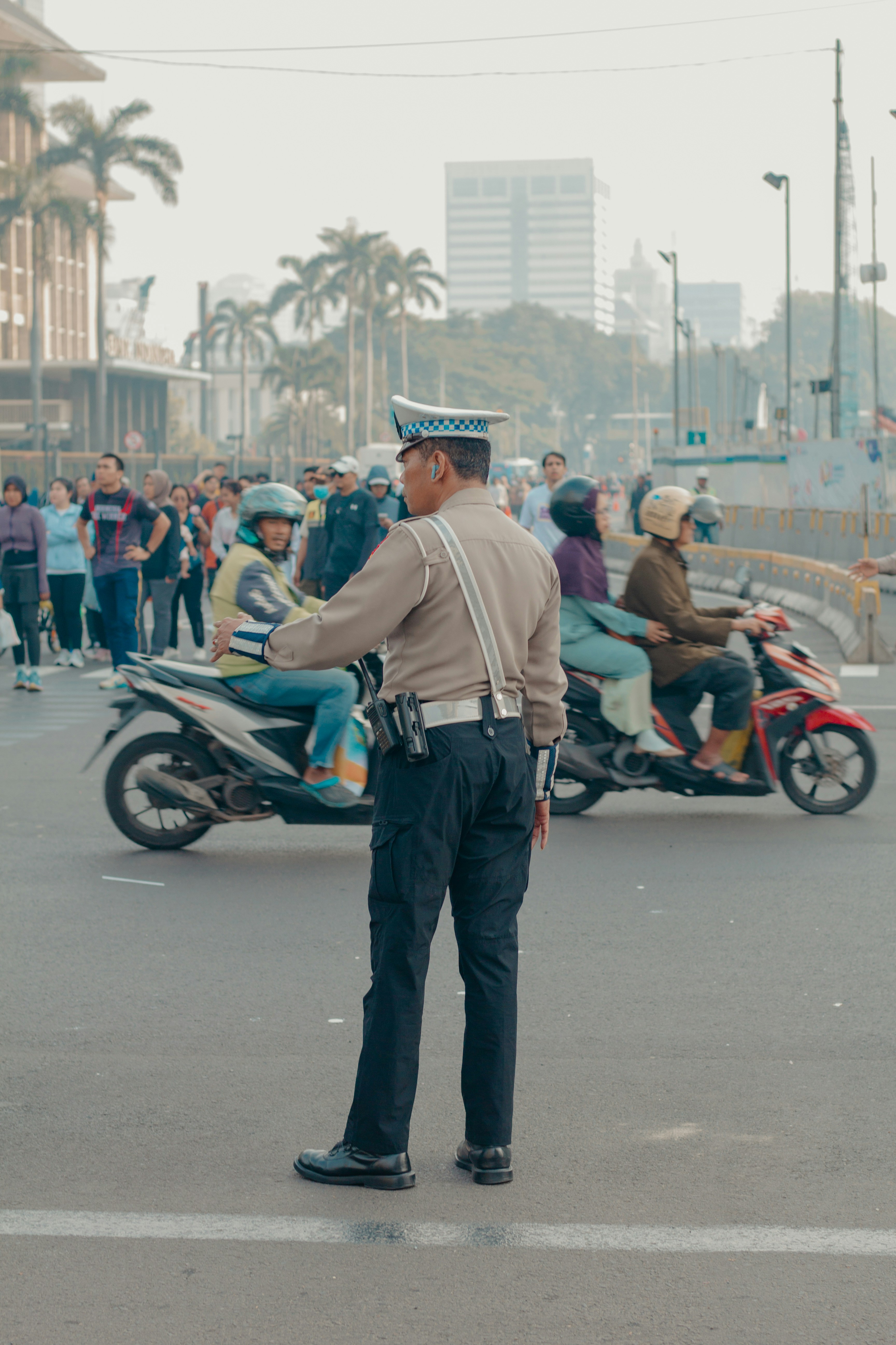 A policeman directs traffic on a busy city street.