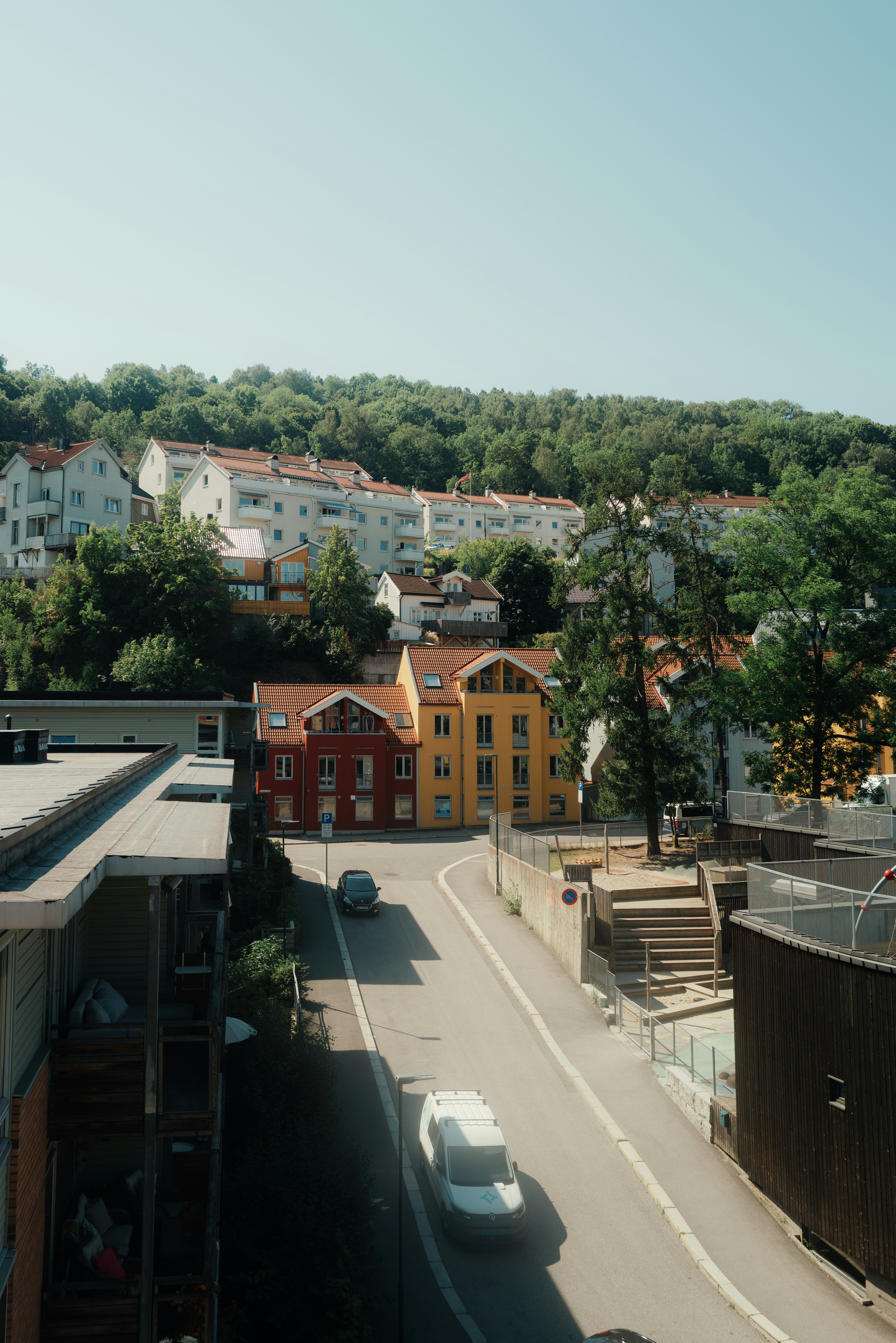 Houses line a road that leads uphill.