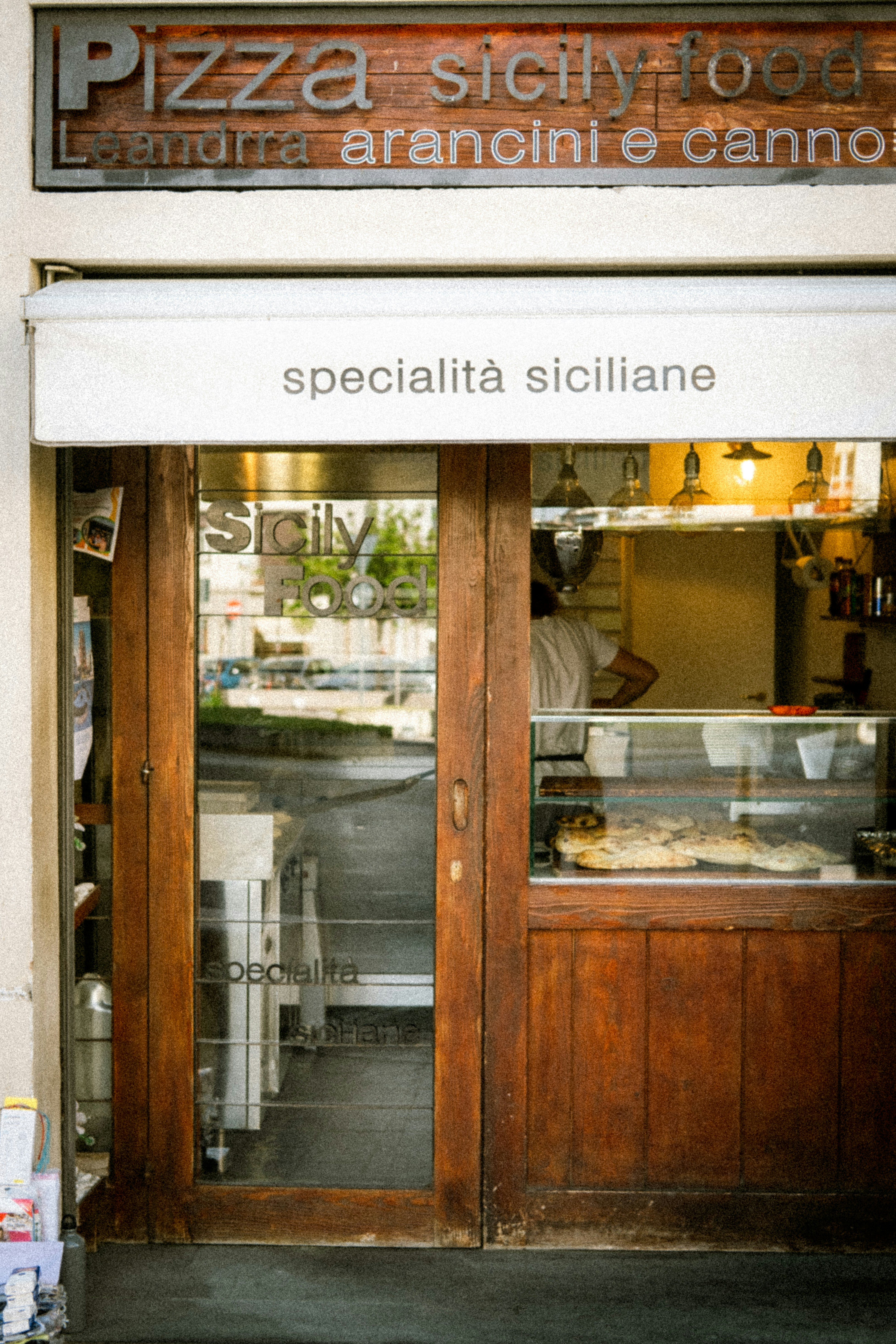 A sicilian restaurant entrance with wooden doors.