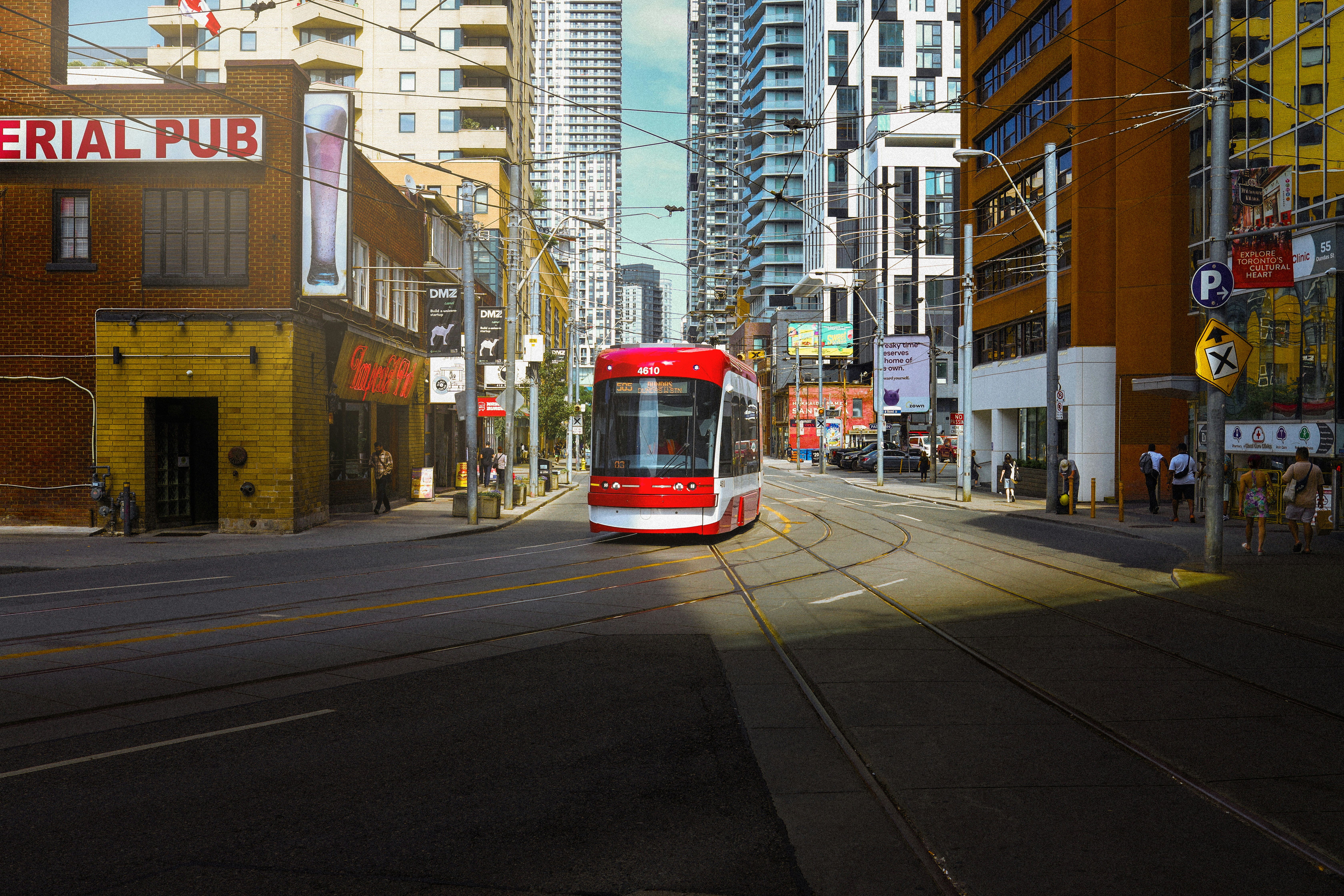 A red streetcar travels down a city street.