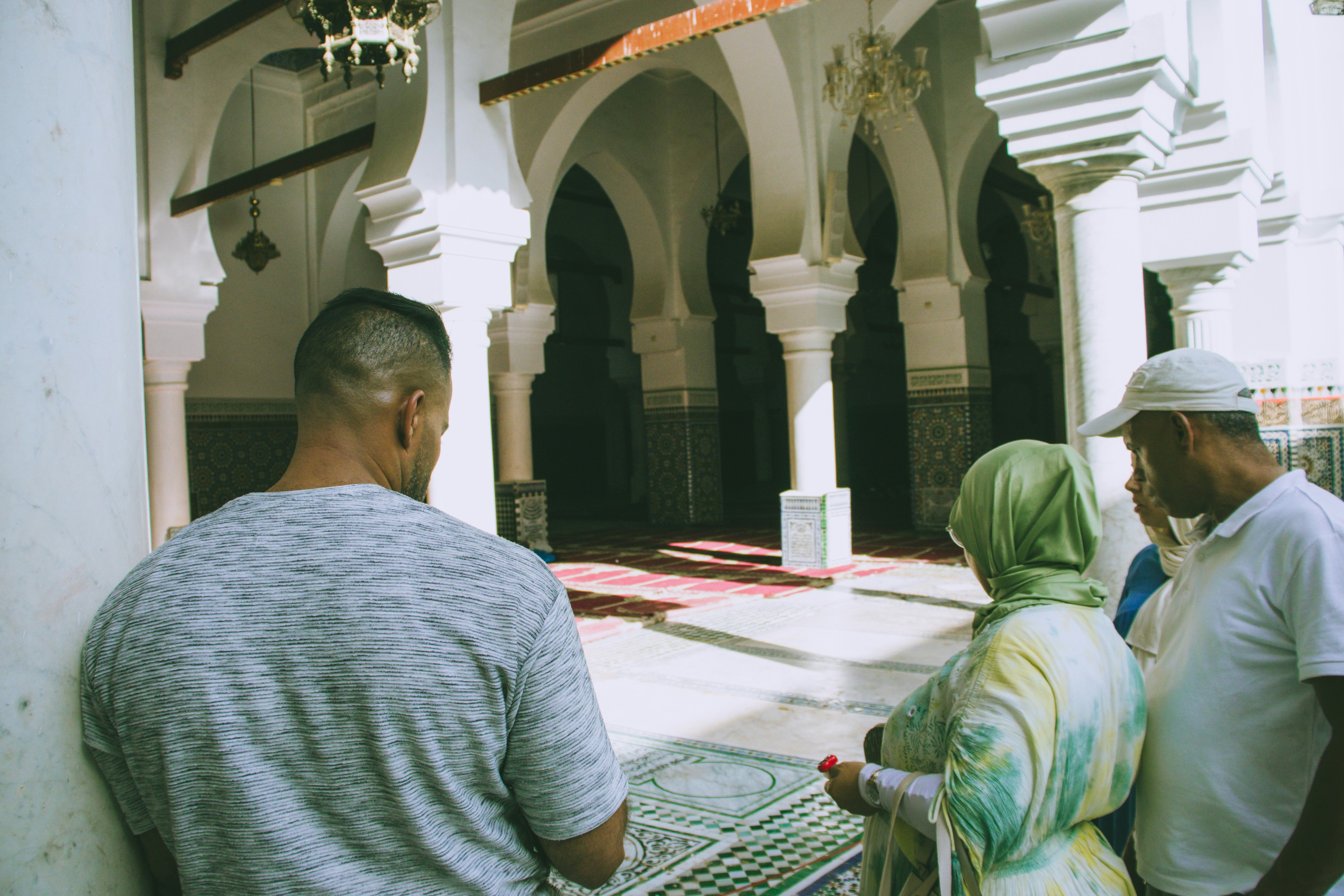 People observe the interior of an arched mosque.