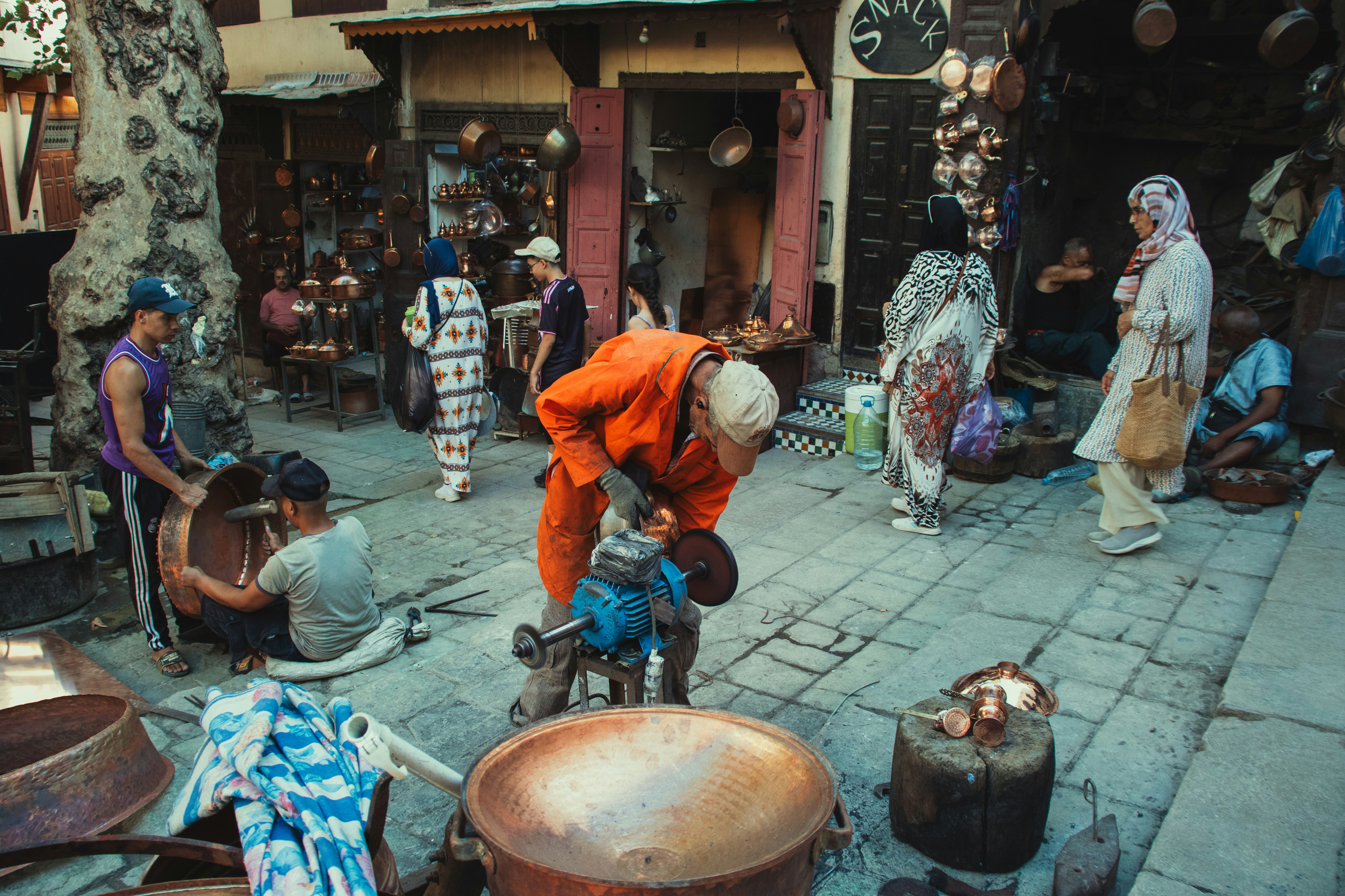 People work and shop in a bustling marketplace.
