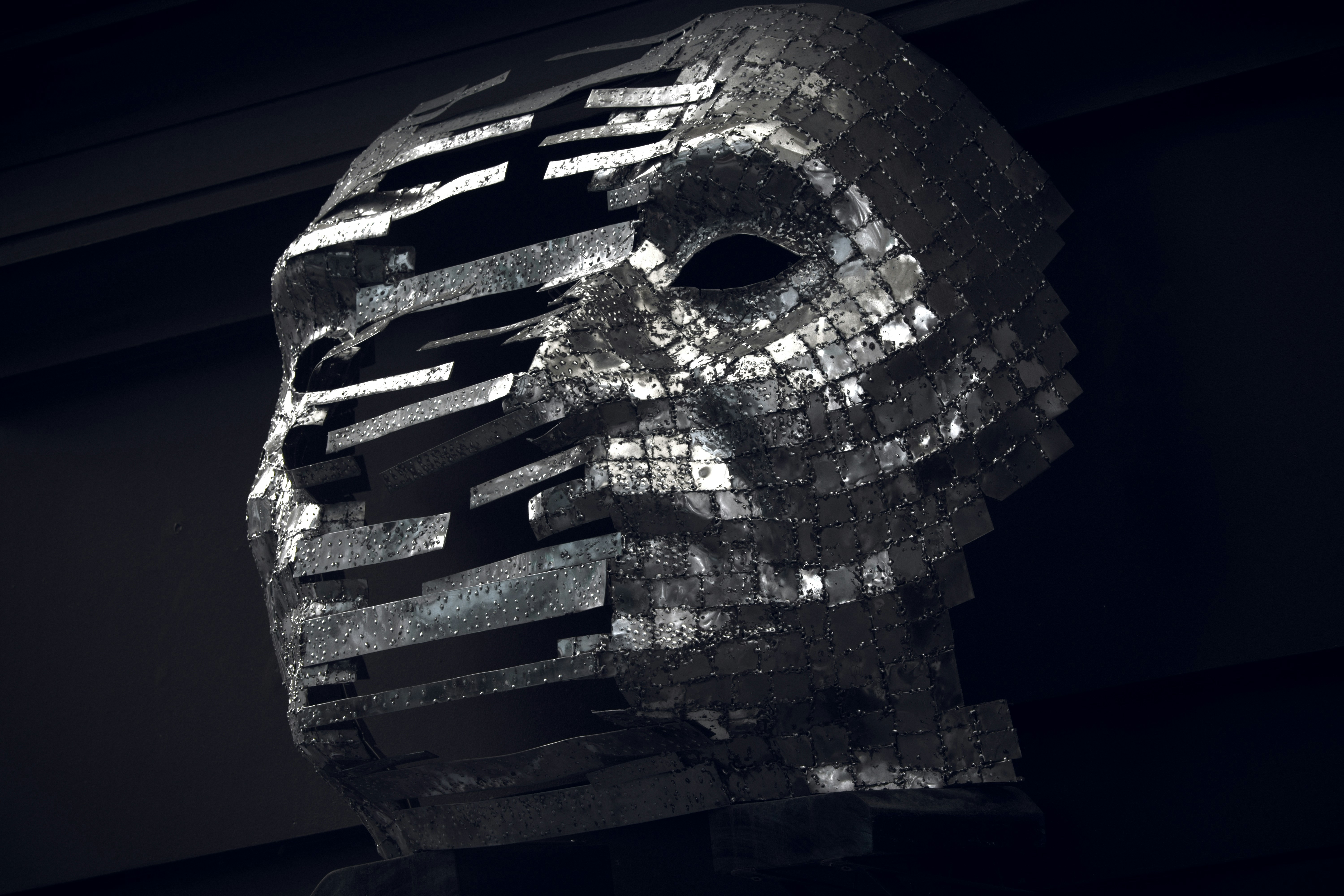 A sliced metallic skull rests in shadows.