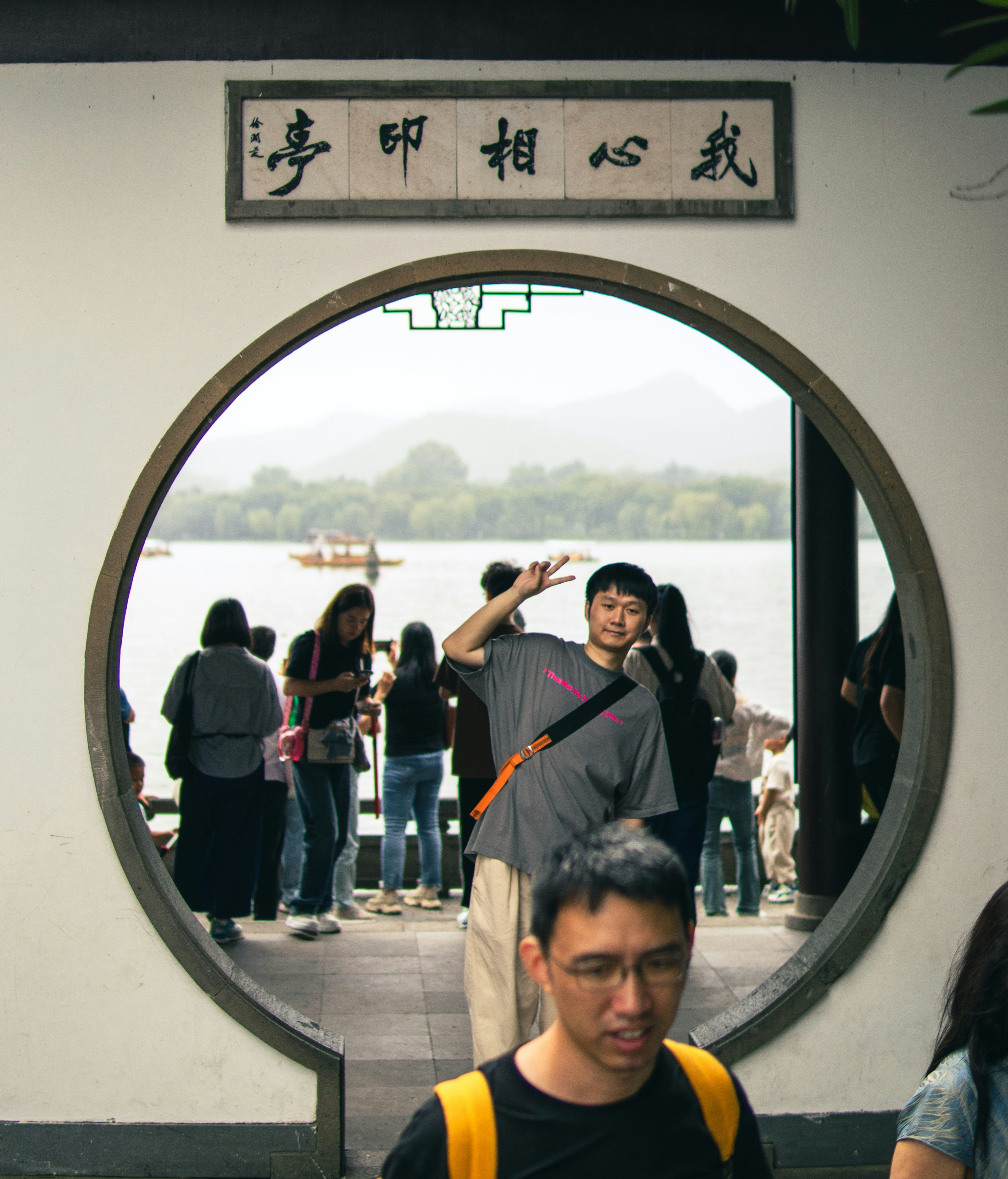 Man poses with a peace sign in an archway.