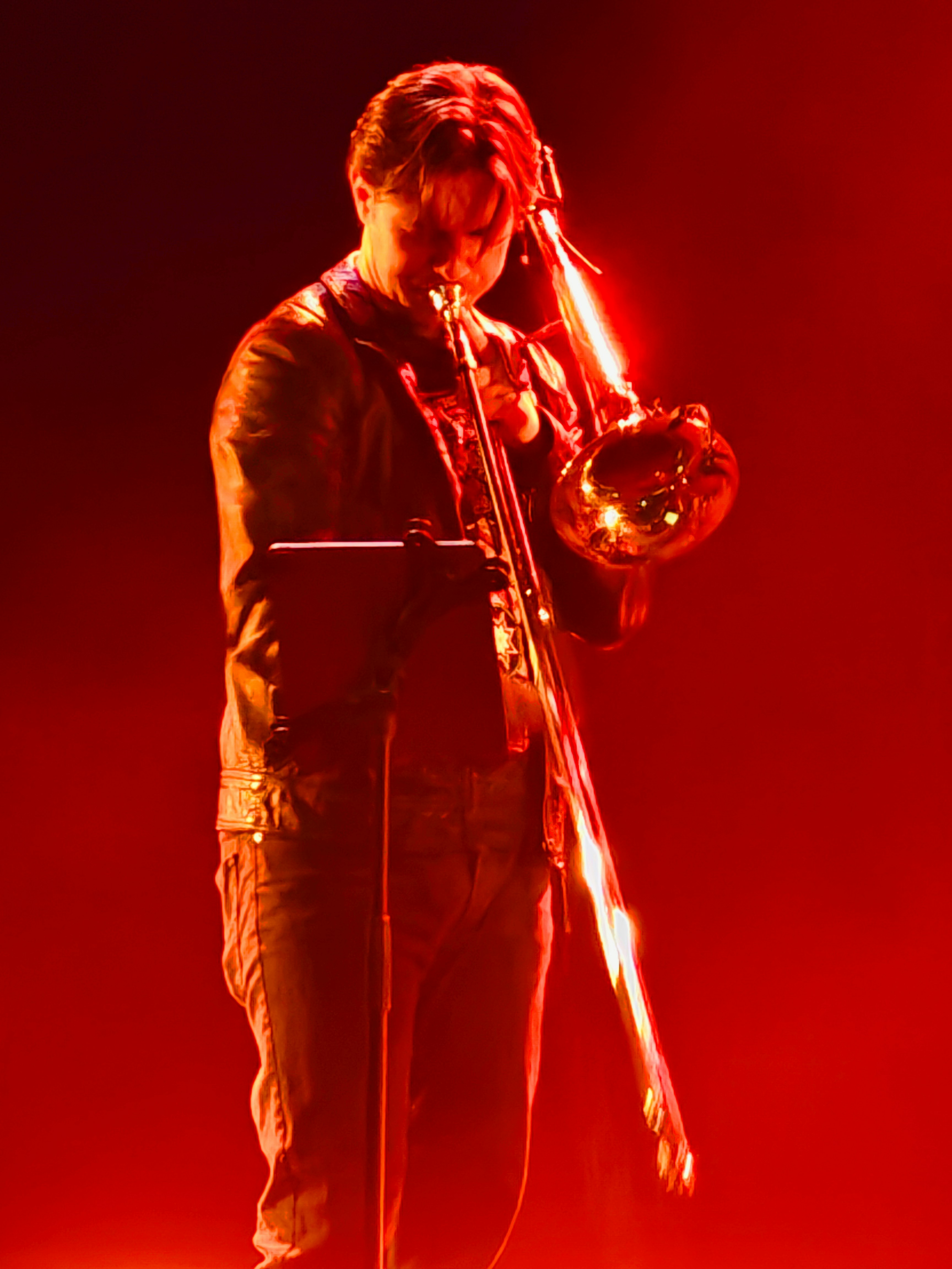 The Symphony & The Red! | A musician plays a trombone on stage.