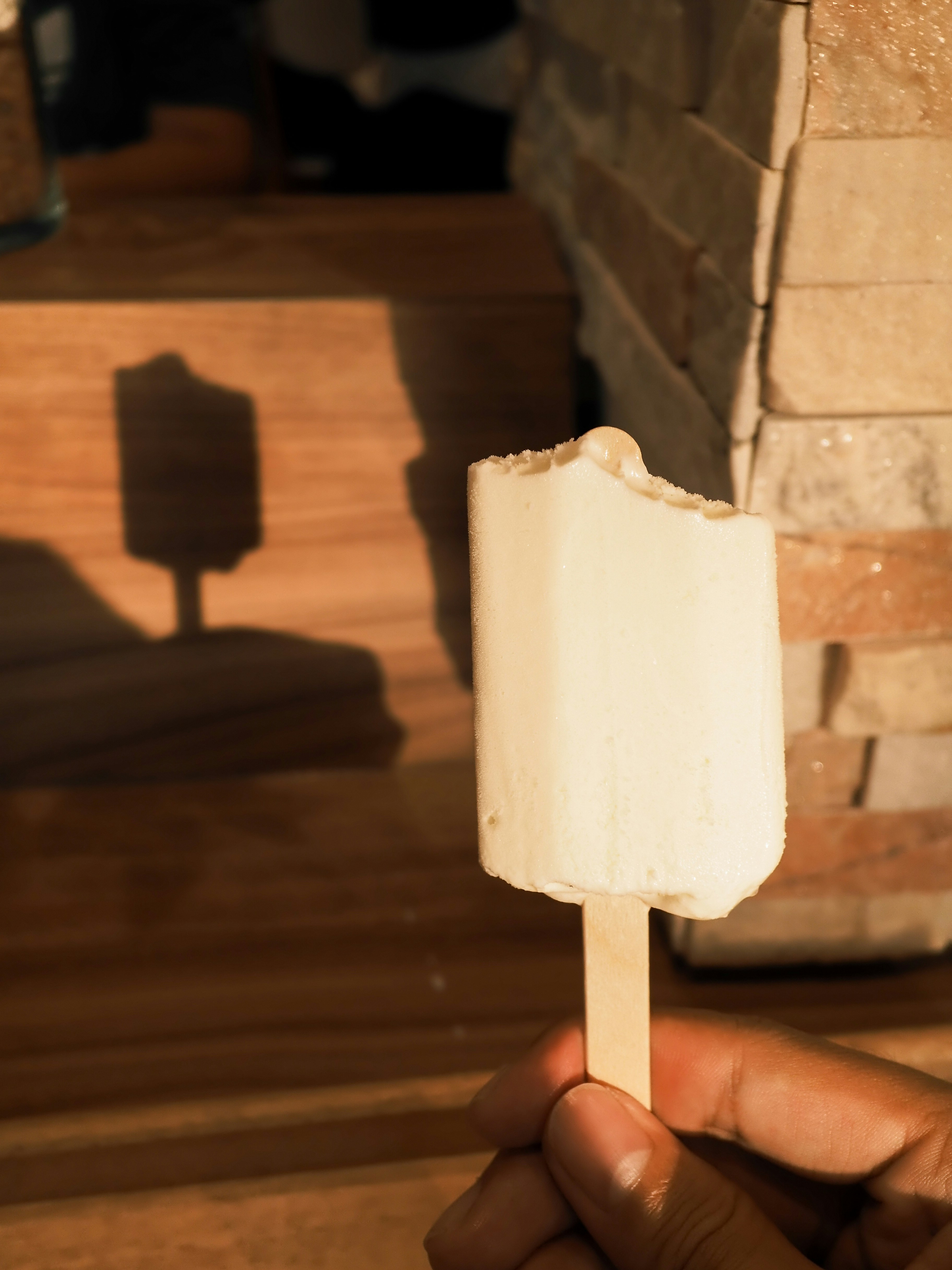 A hand holds a partially eaten popsicle.