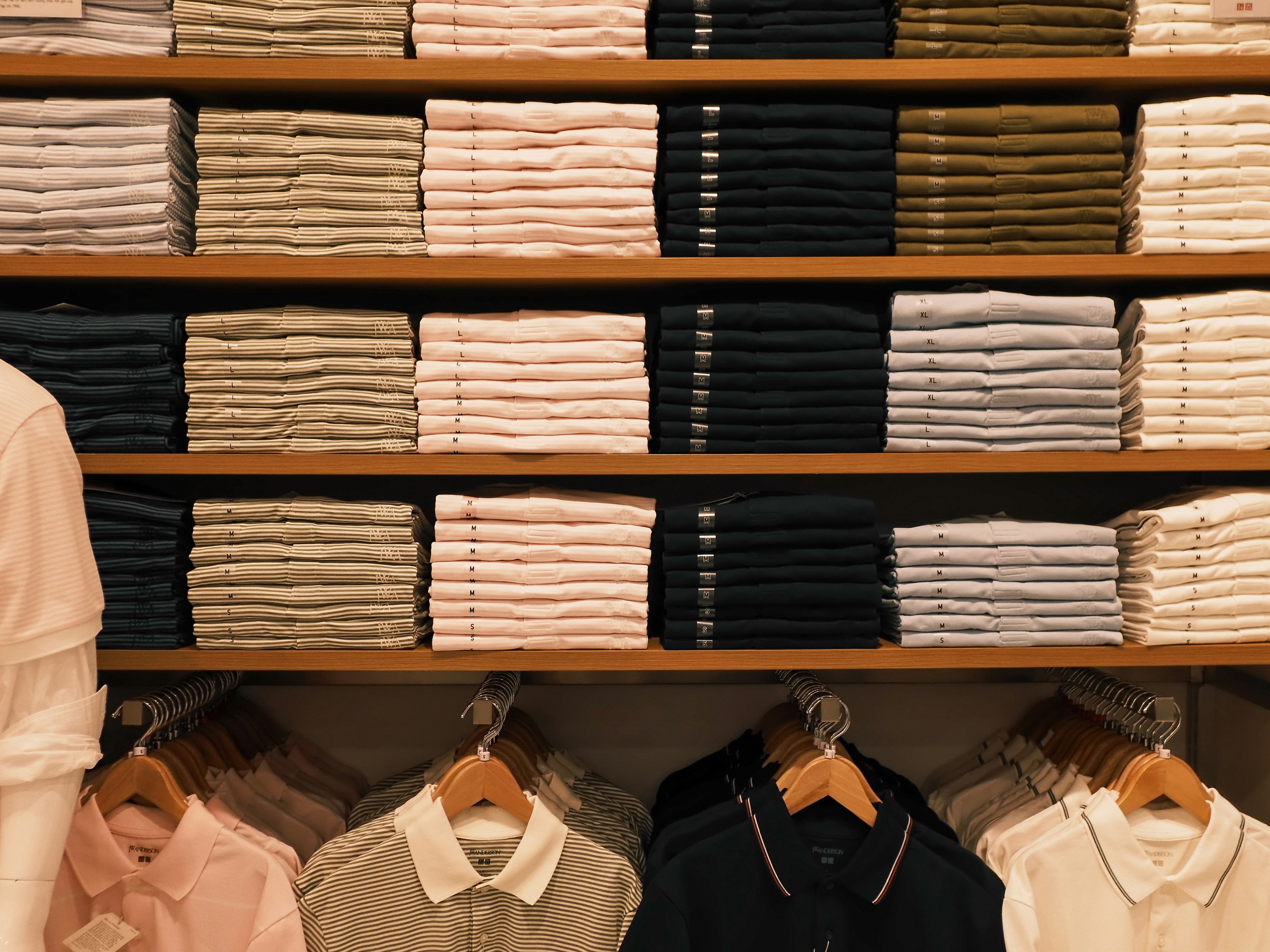 Neatly folded clothes are displayed on shelves.